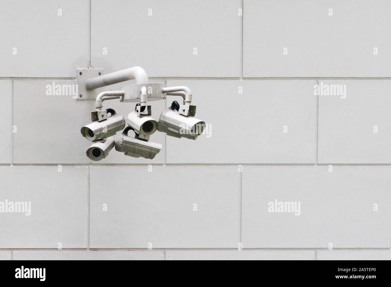 Close-up shot of multiple security cameras attached to a wall in ...