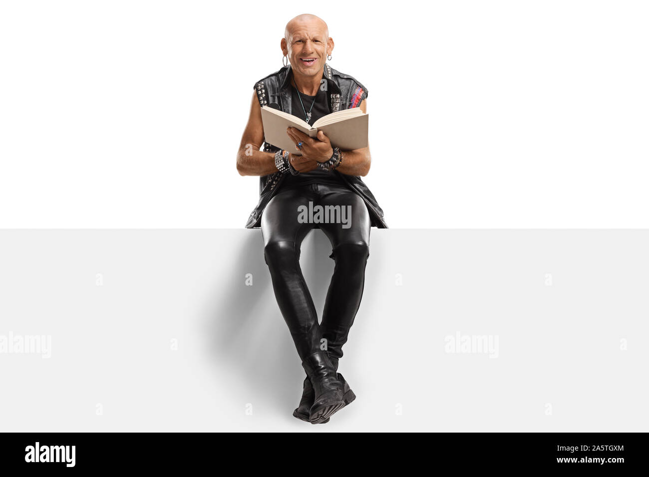 Punk sitting reading a book on a panel and smiling at the camera ...