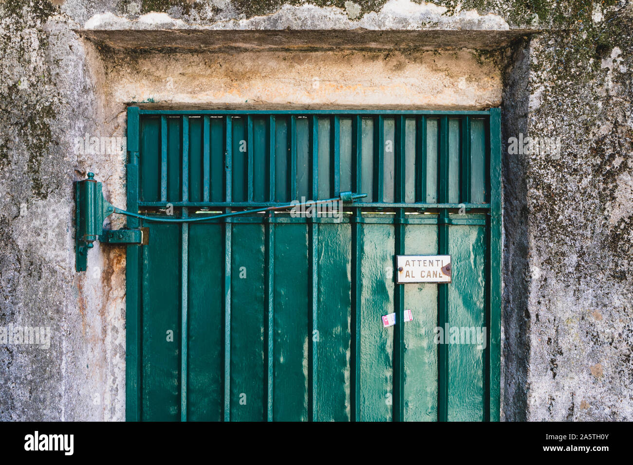 Warning sign Attenti al cane attached to green door - Translation ...