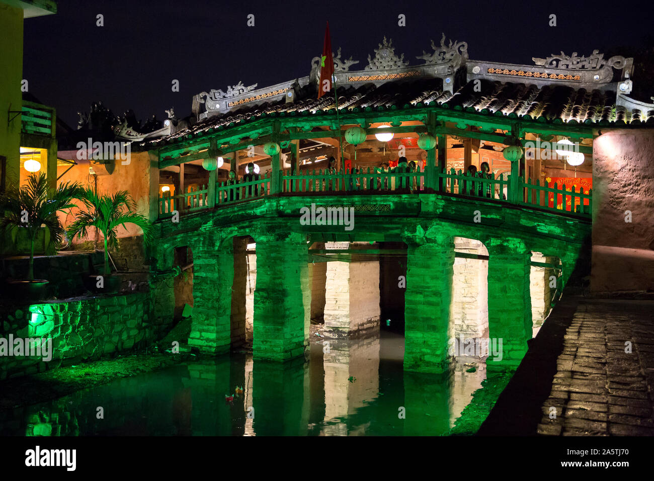 The Japanese Covered Bridge lit up in green light at night in Hoi An ...