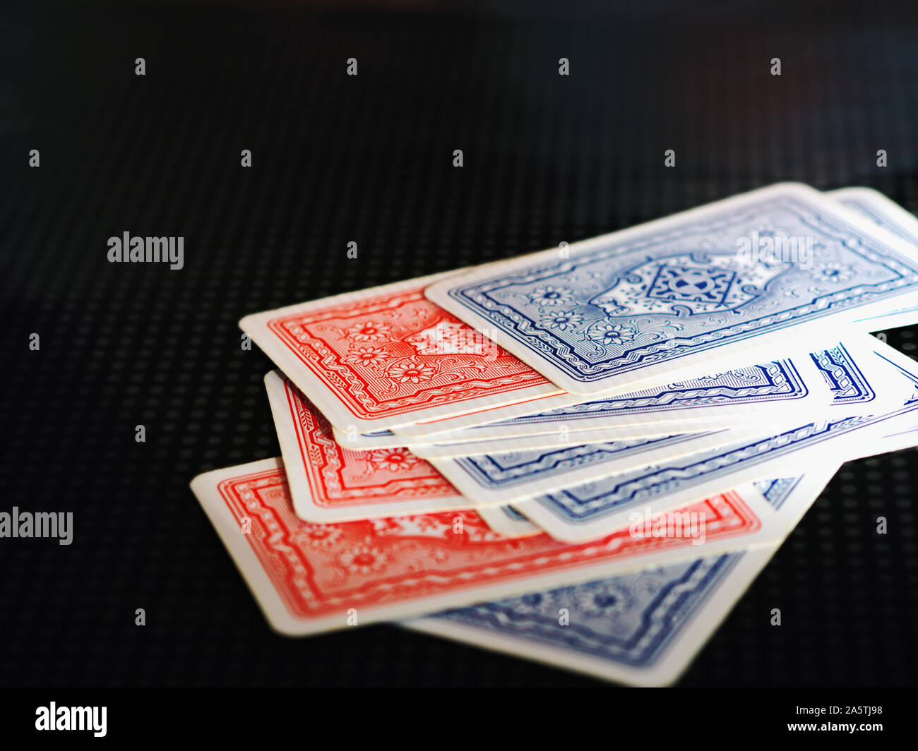 Playing cards in blue and red design with the backside are lying on a ...