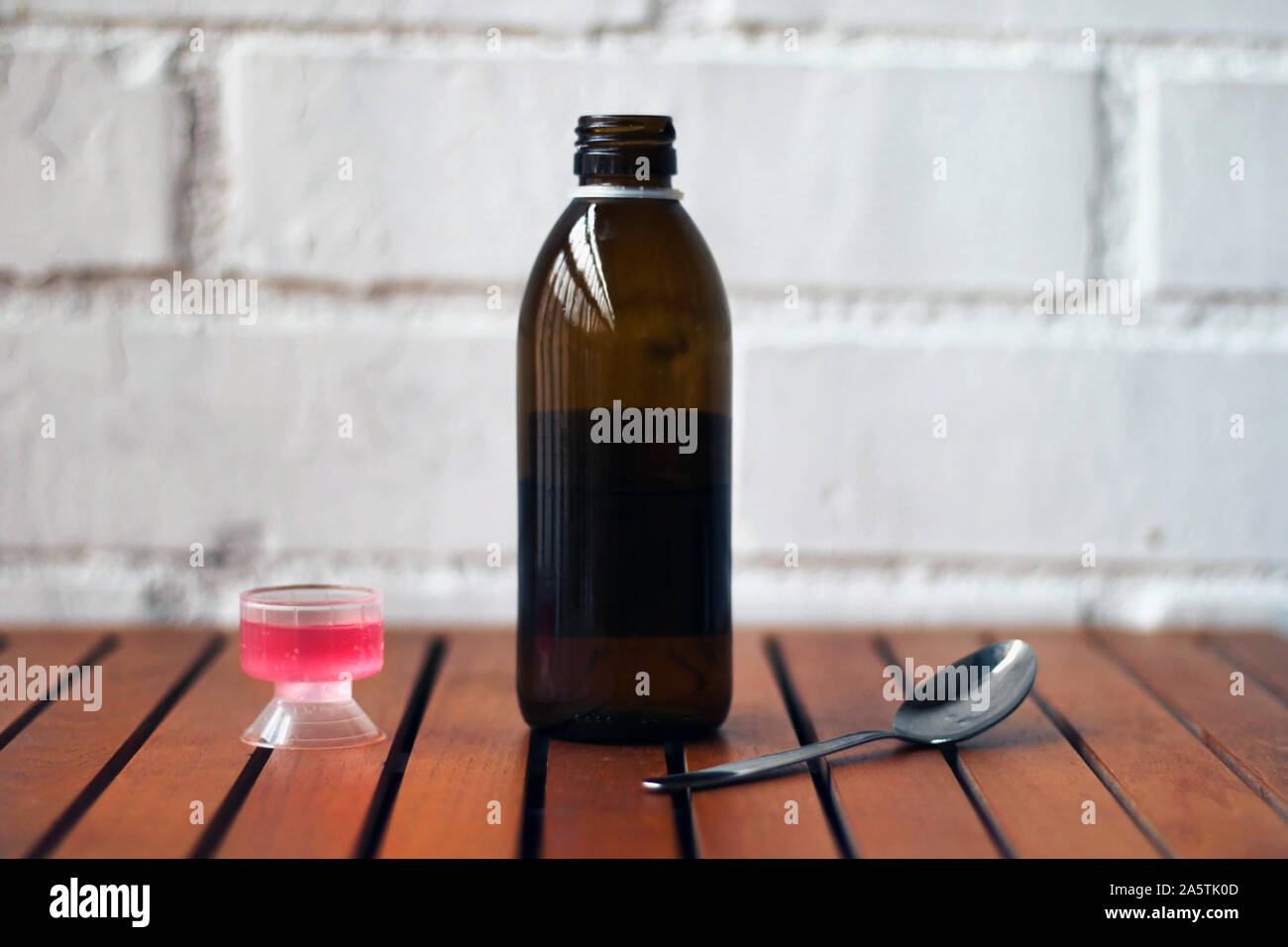 Healthcare and medicine concept - Bottle of cough syrup next to a spoon ...
