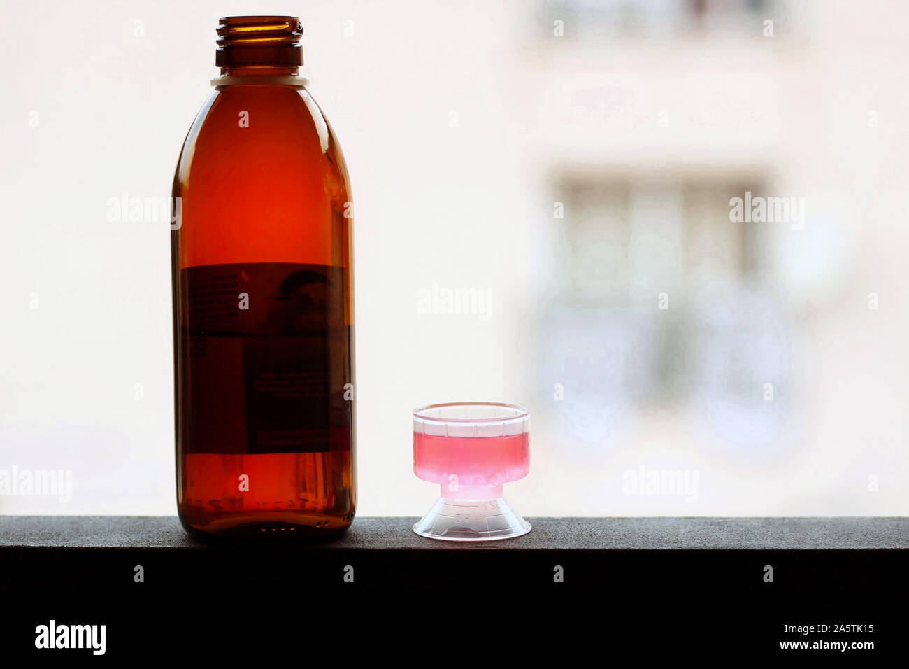 Healthcare and medicine concept - Bottle of cough syrup in a white ...