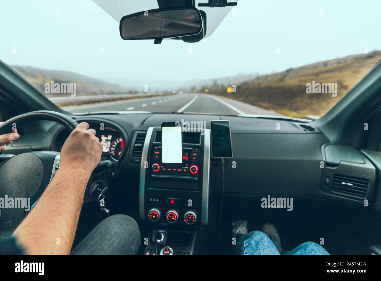 car travel concept autumn highway phone with white screen on dashboard ...