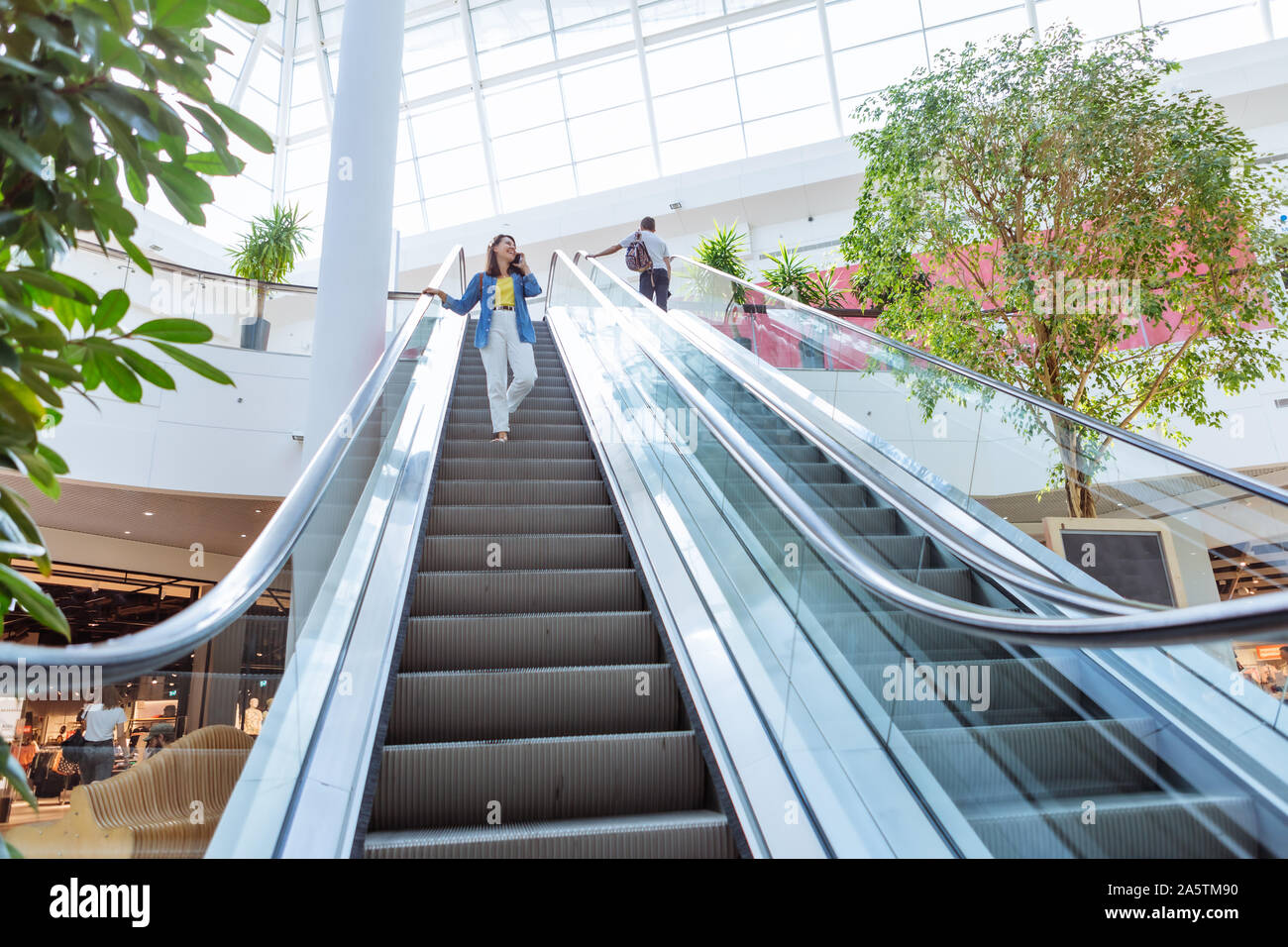 woman in city mall walking to escalator Stock Photo - Alamy