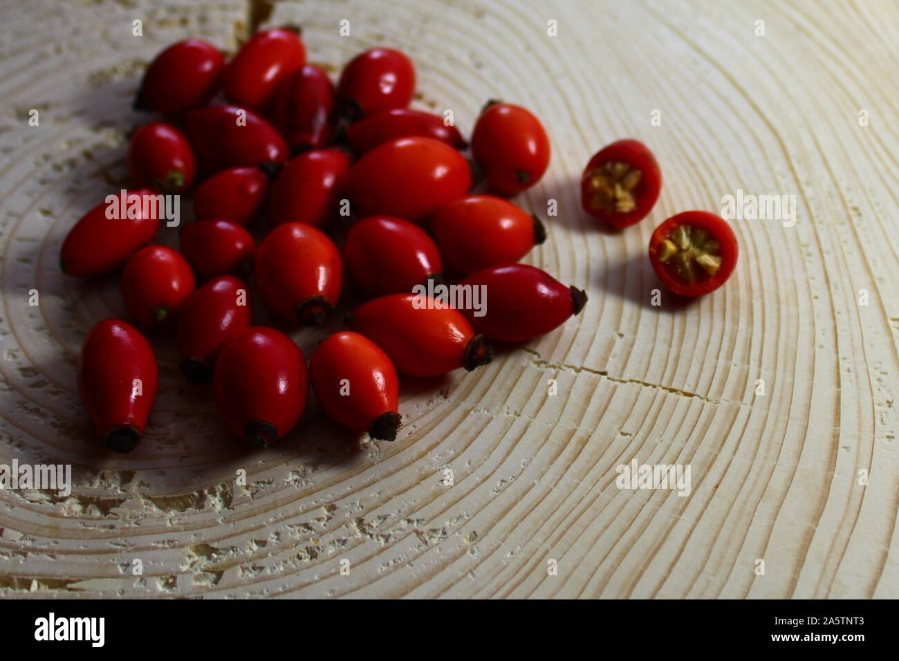The picture shows rose hips on wooden ground Stock Photo - Alamy