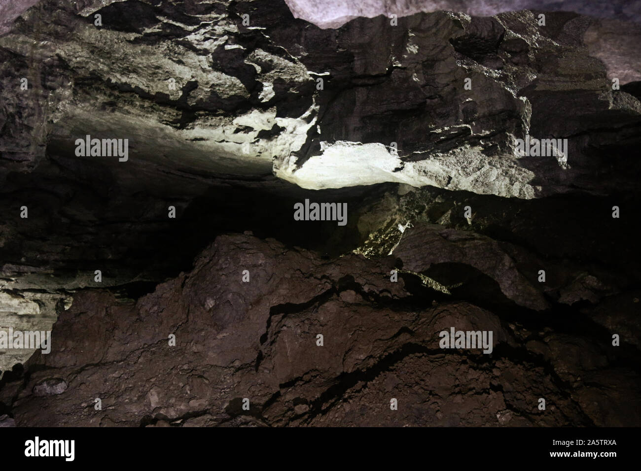 Half-filled with rock and clay natural cave. After collapse of ...