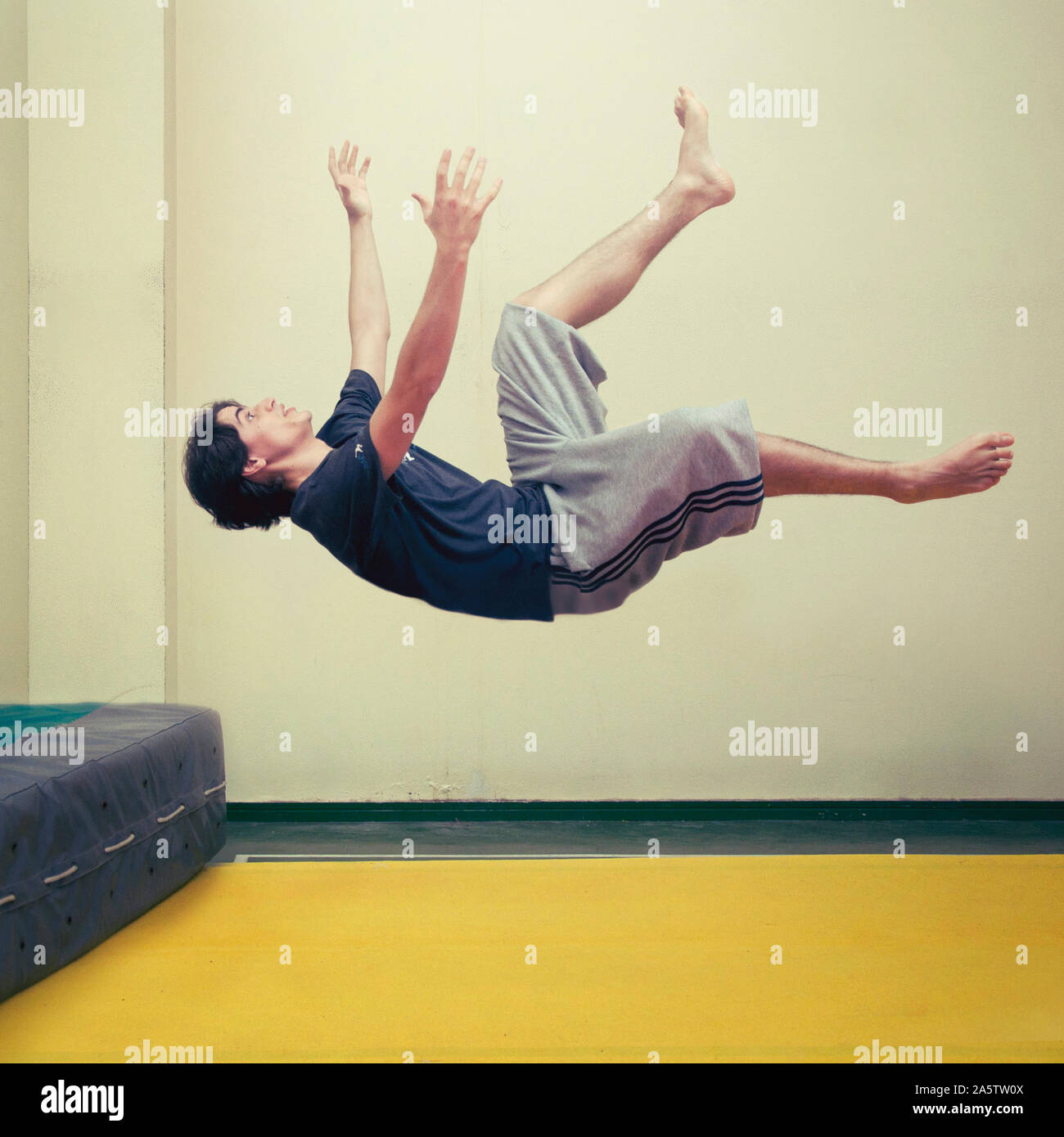 Young man just slipped doing gymnastics and is falling to the ground ...