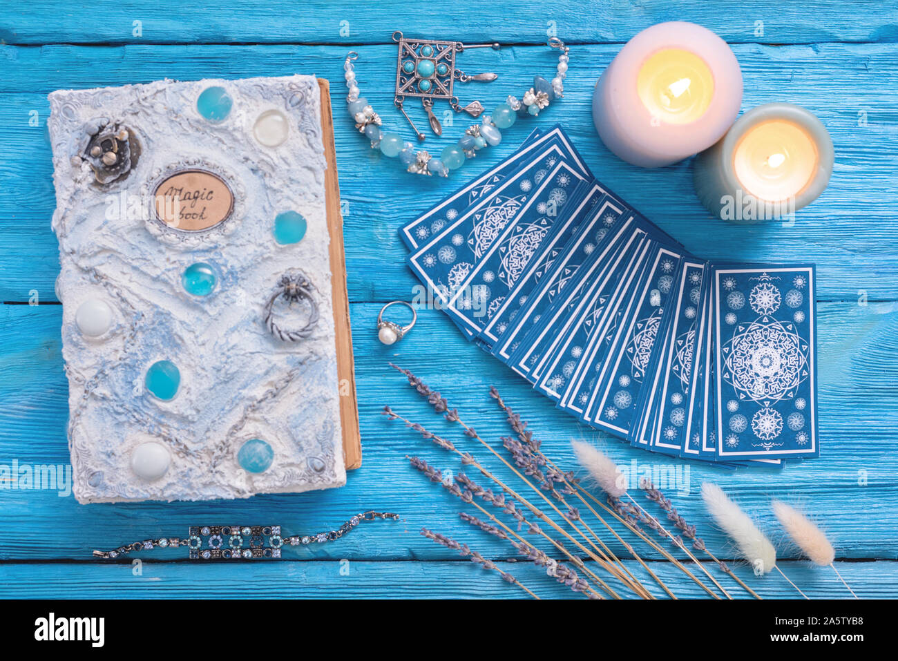 Blue tarot cards deck and white magic book on blue wooden table ...