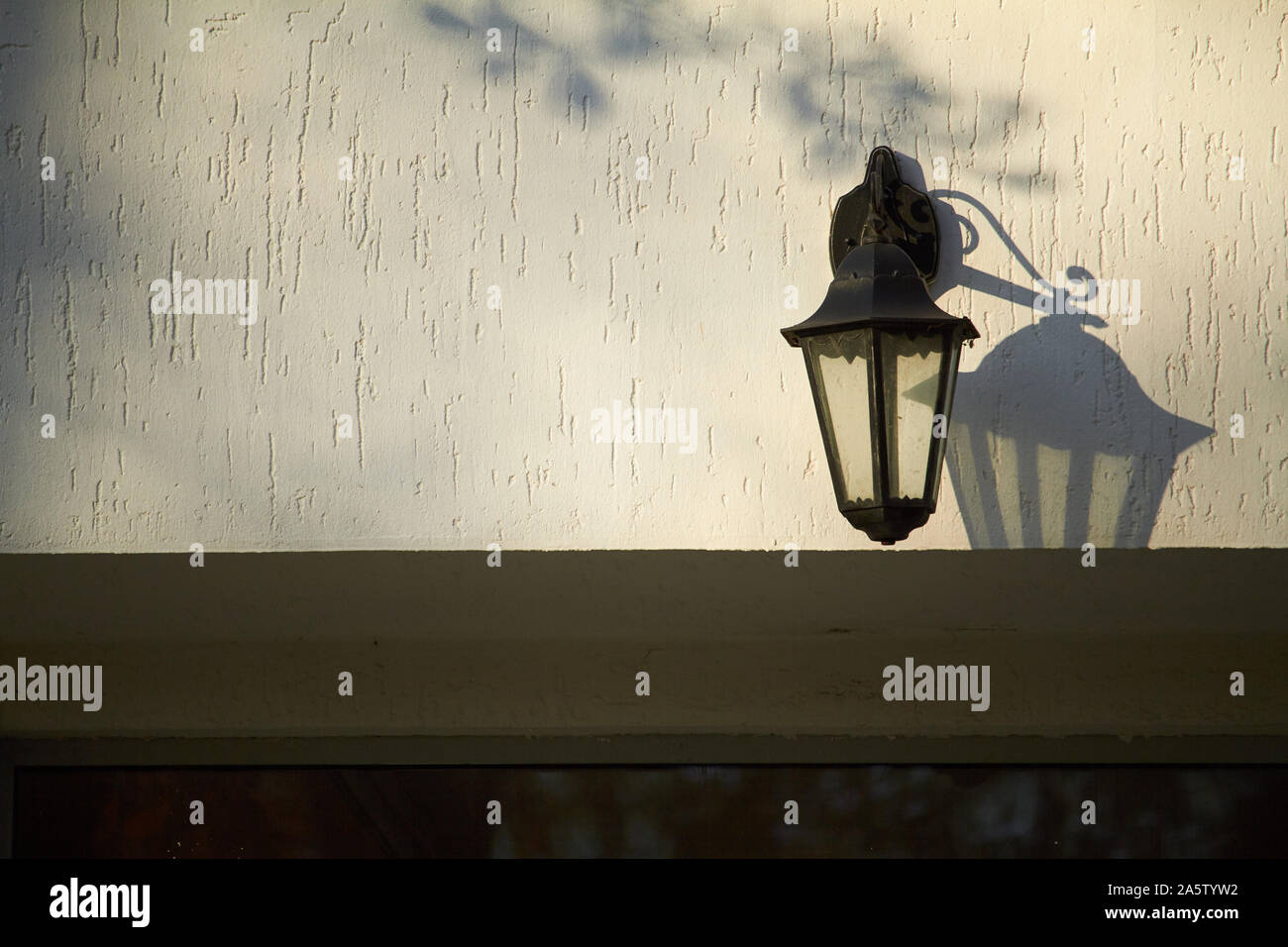 Street lamp and its shadow on white wall background Stock Photo - Alamy