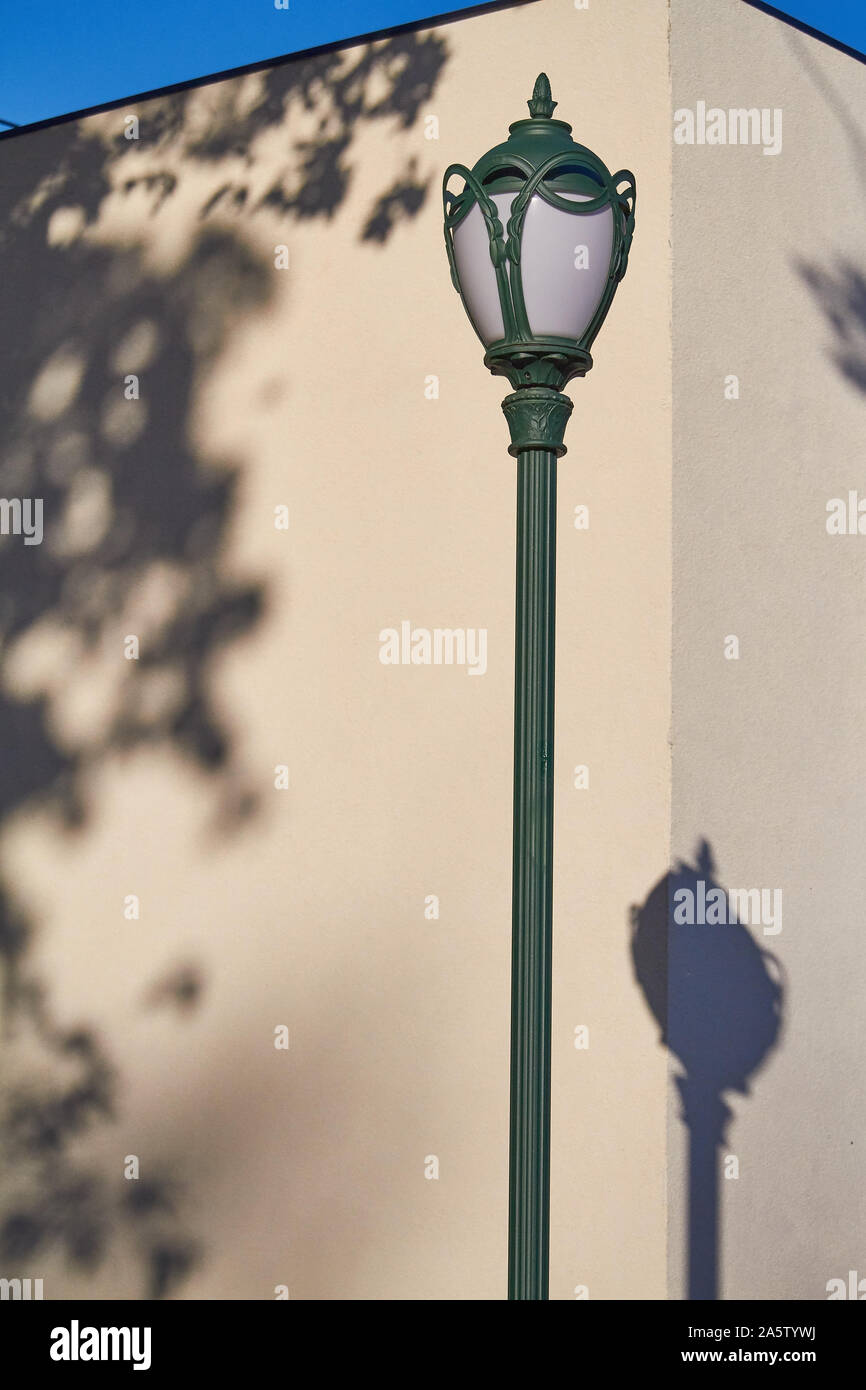 Street lamp and its shadow on white wall background Stock Photo - Alamy
