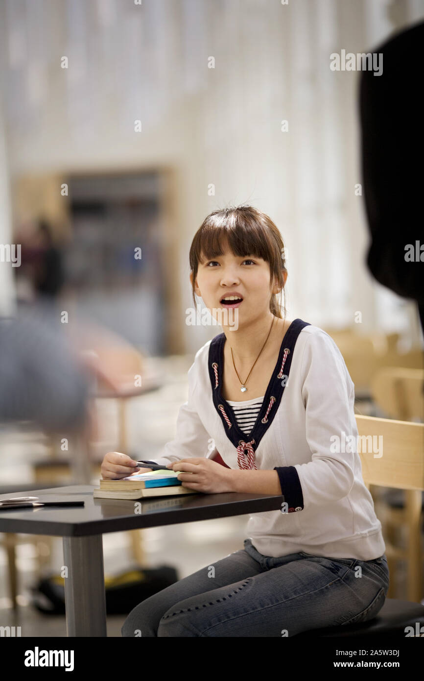 Teenage girl sitting in a study hall Stock Photo - Alamy