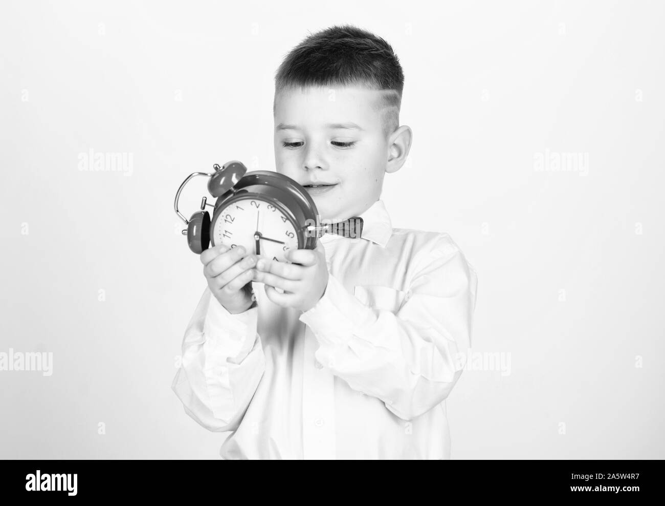 little boy with alarm clock. Time to relax. tuxedo kid. Happy childhood ...
