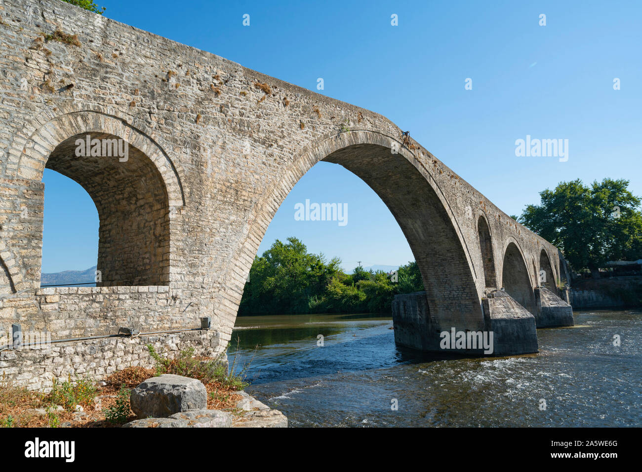 Arches of ancient stone pedestrian bridge at Arta over Arachthos River ...