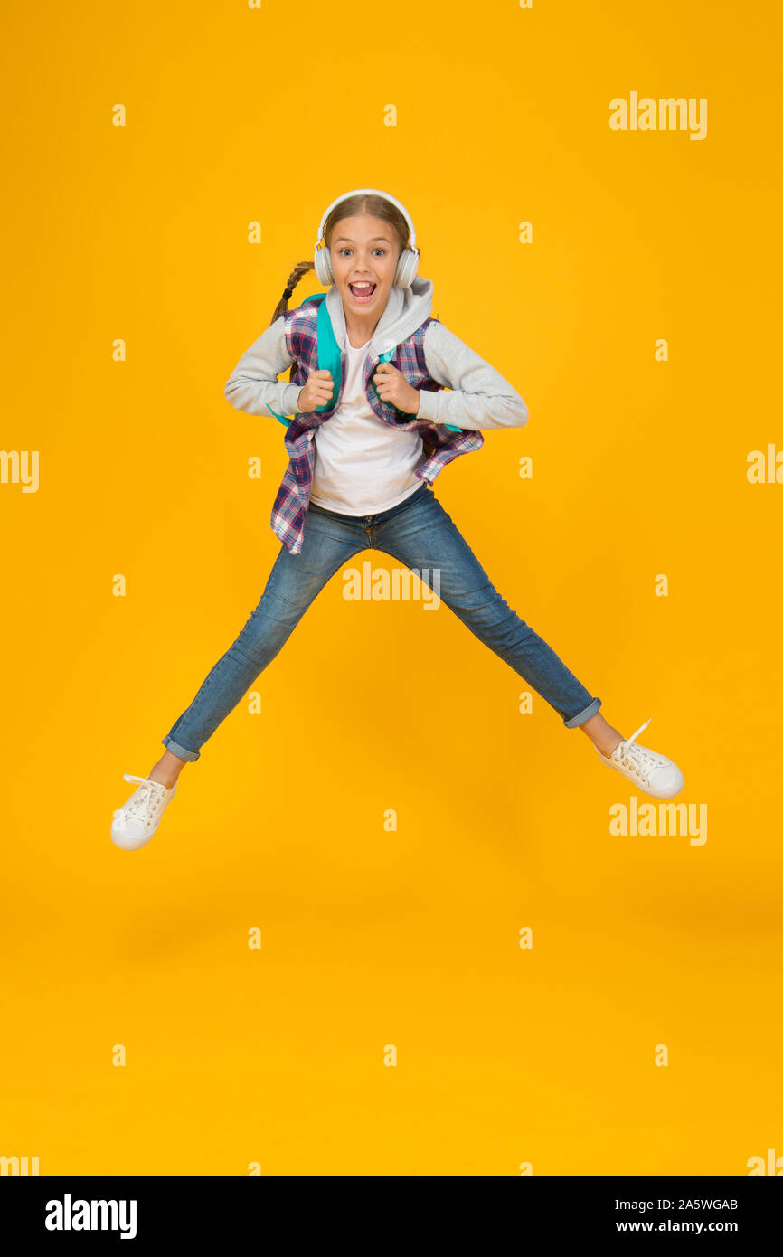 Energetic and enthusiastic. Energized small girl jump high with ...