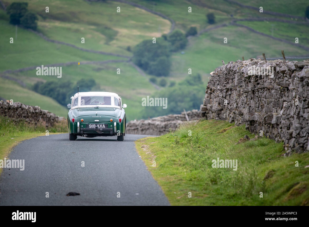 A classic Triumph TR3A drives along the rural backroads of Hawes ...