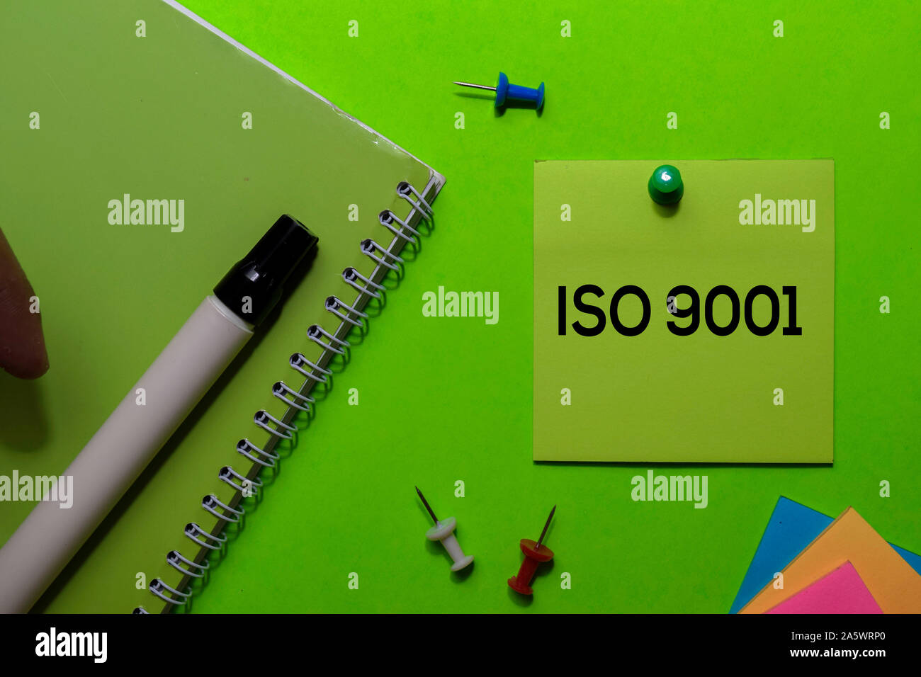 ISO 9001 write on sticky notes. Isolated on green table background ...