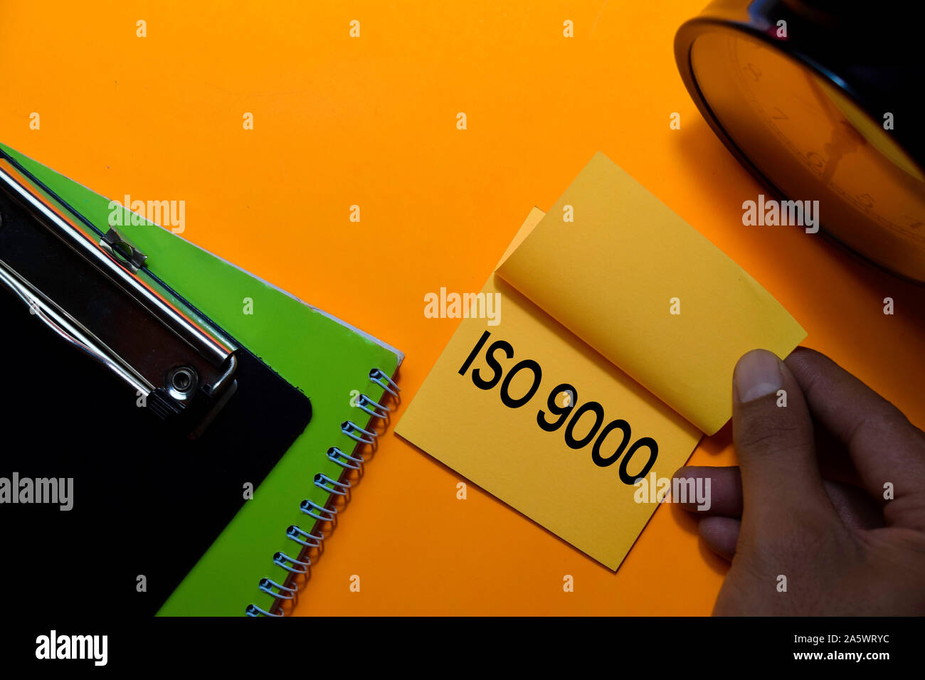 ISO 9000 write on sticky notes. Isolated on orange table background ...