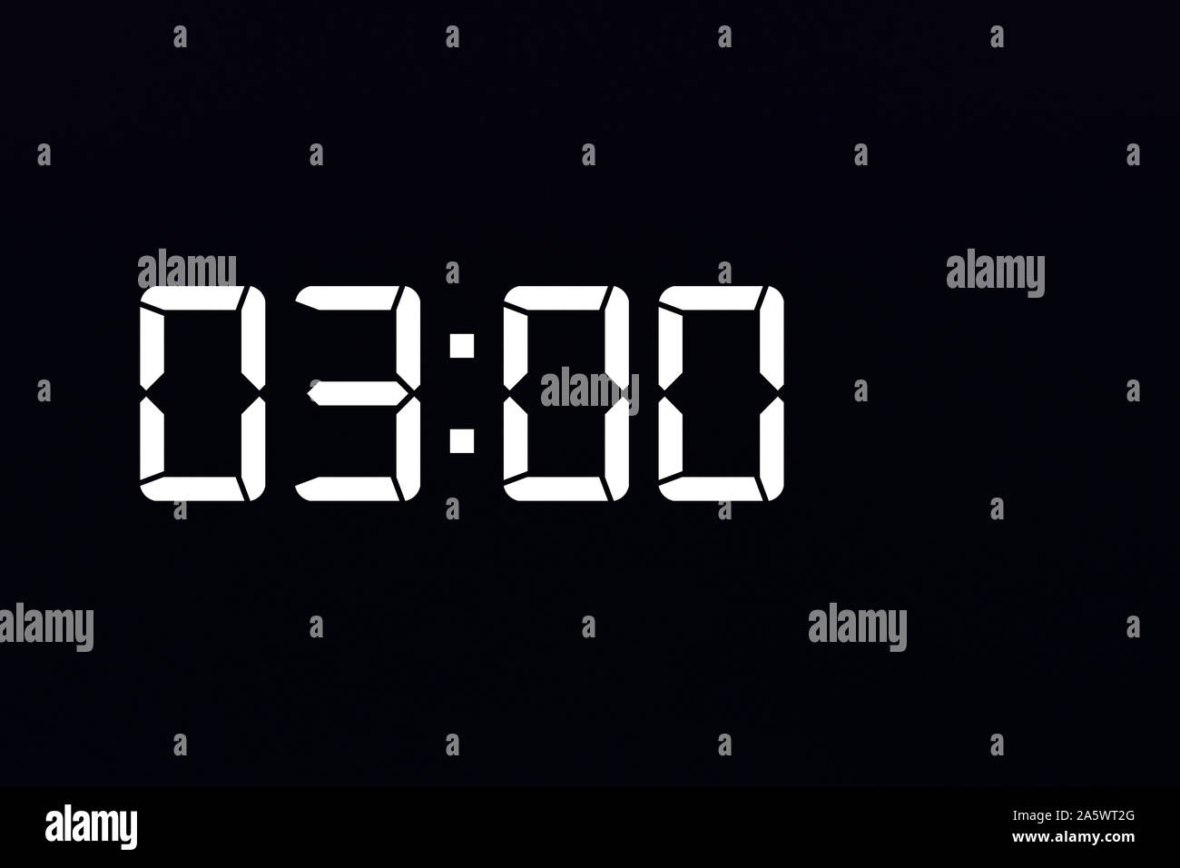 Showing time 03:00 on white led digital clock isolated black background ...