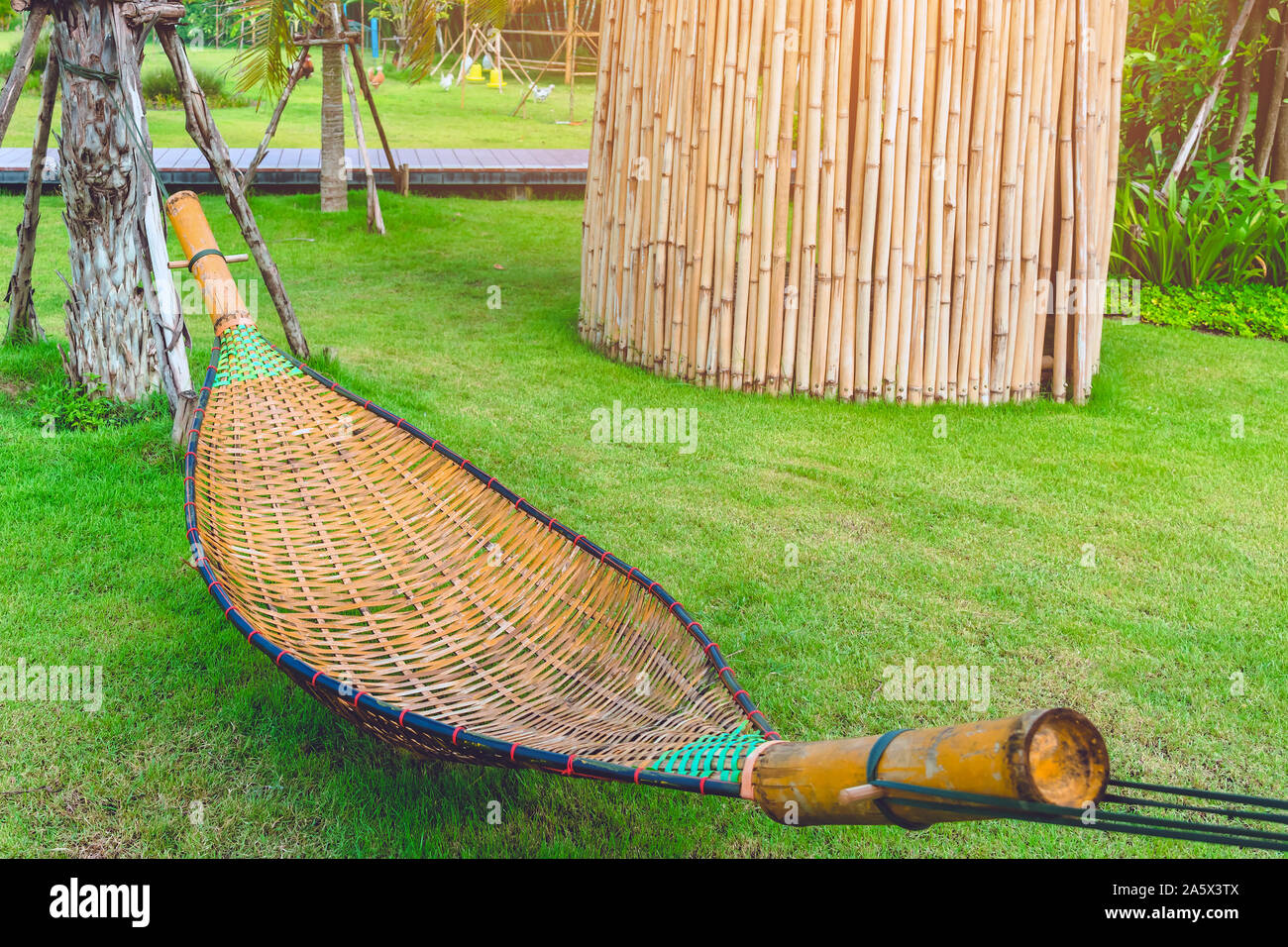 Bamboo wicker hammock hanging on tree for relaxing in the public garden ...