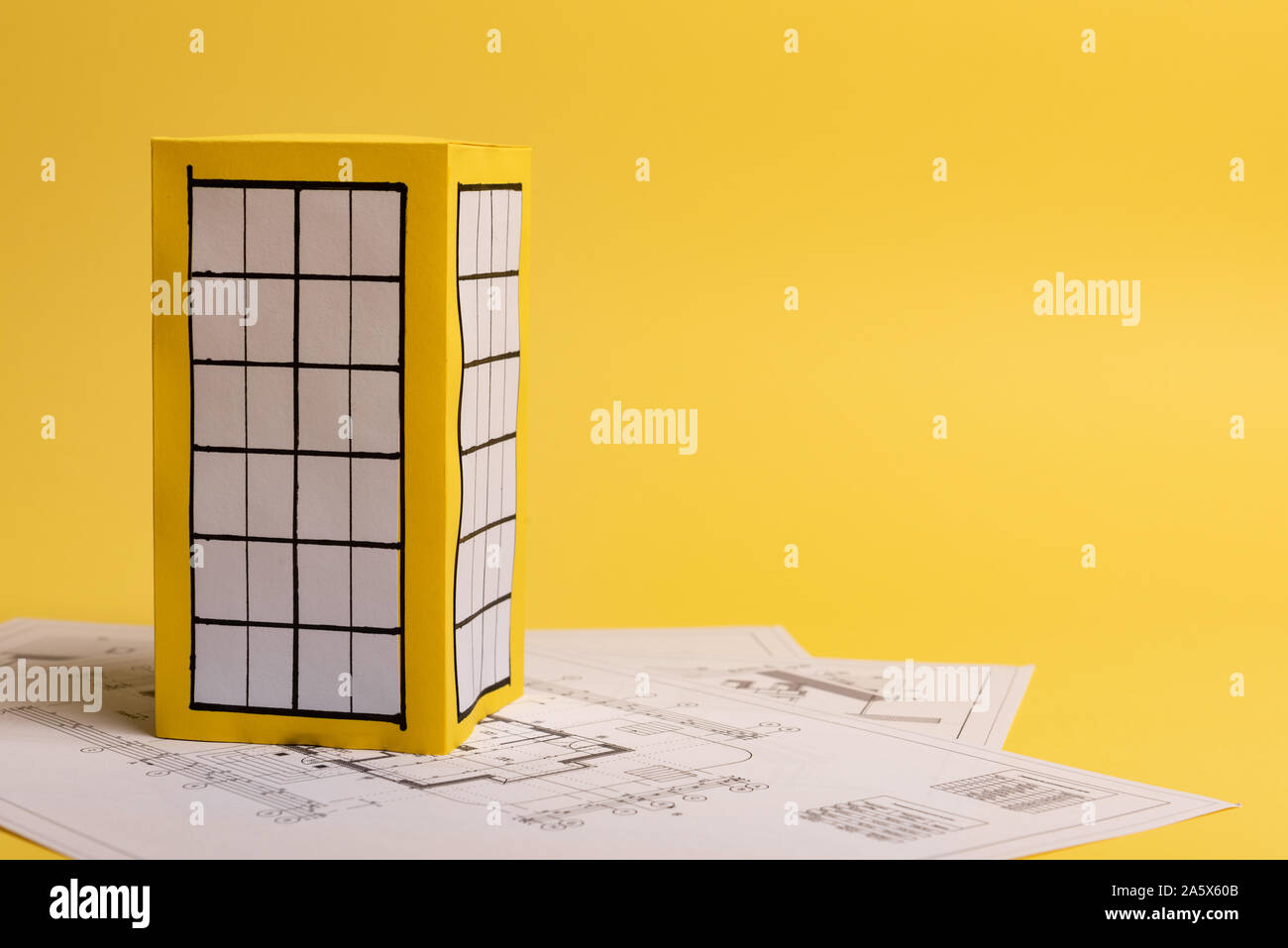 Yellow paper block of flats on yellow background paper. Minimalistic ...