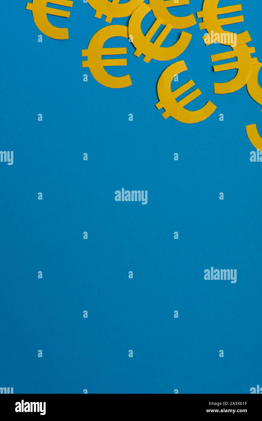 Paper yellow symbols of euro currency on blue background. View from ...