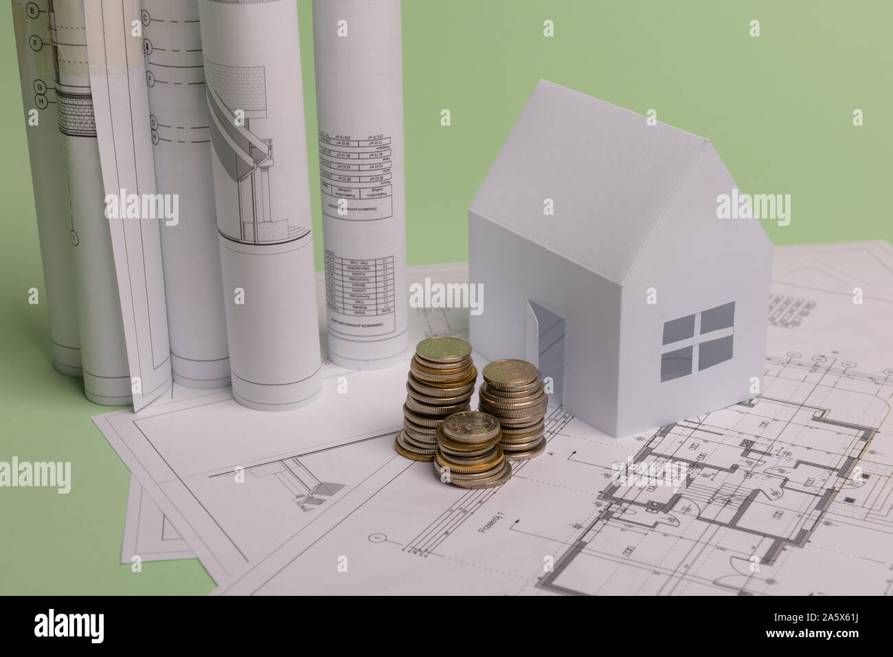 White family paper house , stack of money coins, house projects plan ...