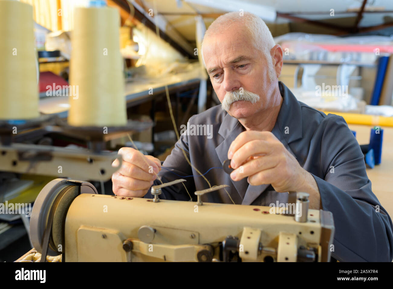 man threading up sewing machine Stock Photo - Alamy