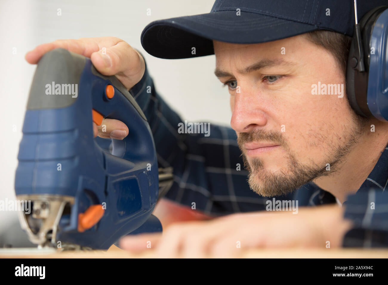 man cutting wood with a saw inside Stock Photo - Alamy