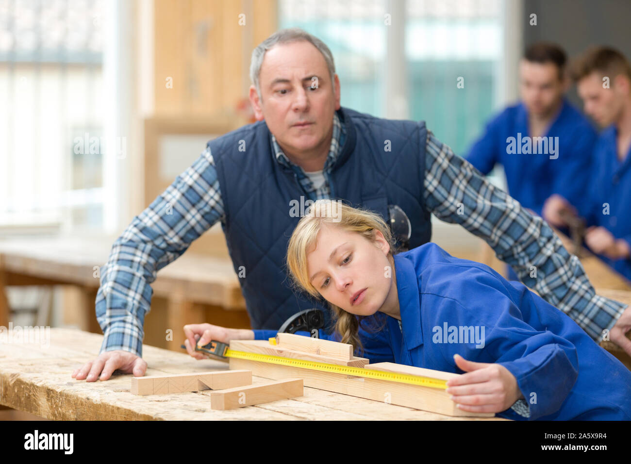 young woodworking apprentice measuring wood Stock Photo - Alamy