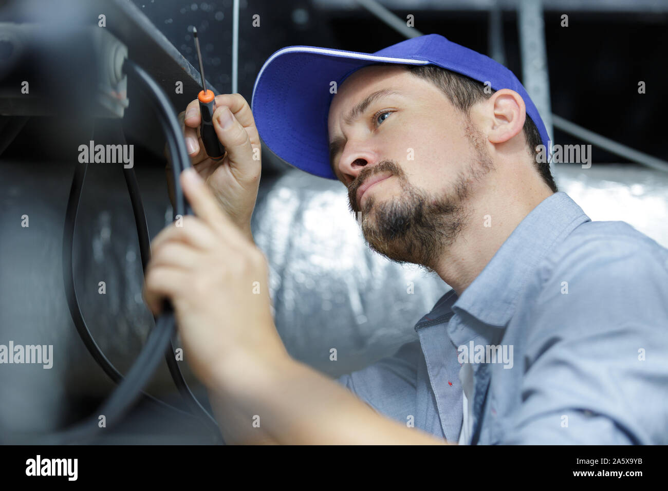 a male worker is checking electrical connections Stock Photo - Alamy