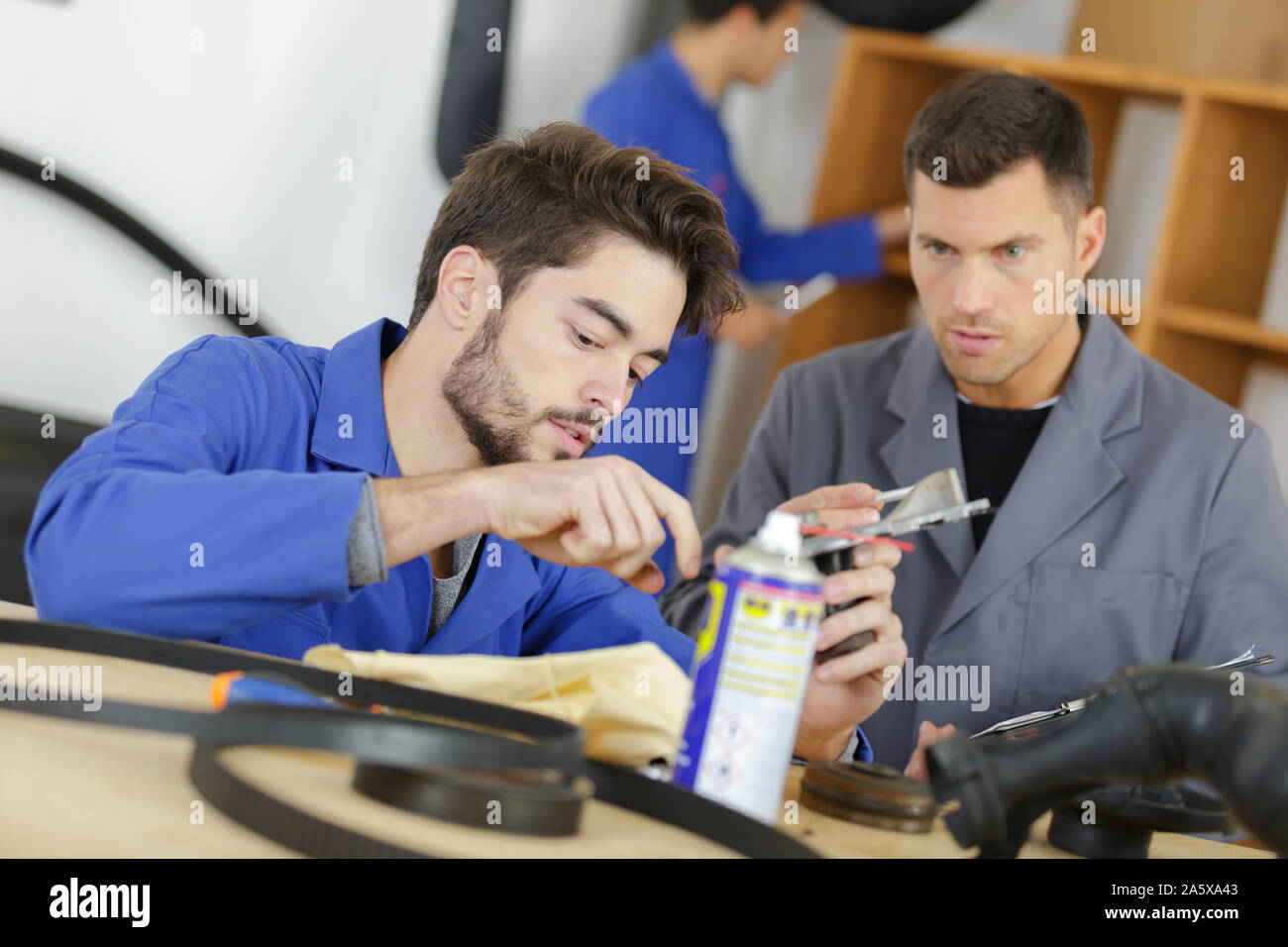 young mechanical apprentice with engine parts Stock Photo - Alamy