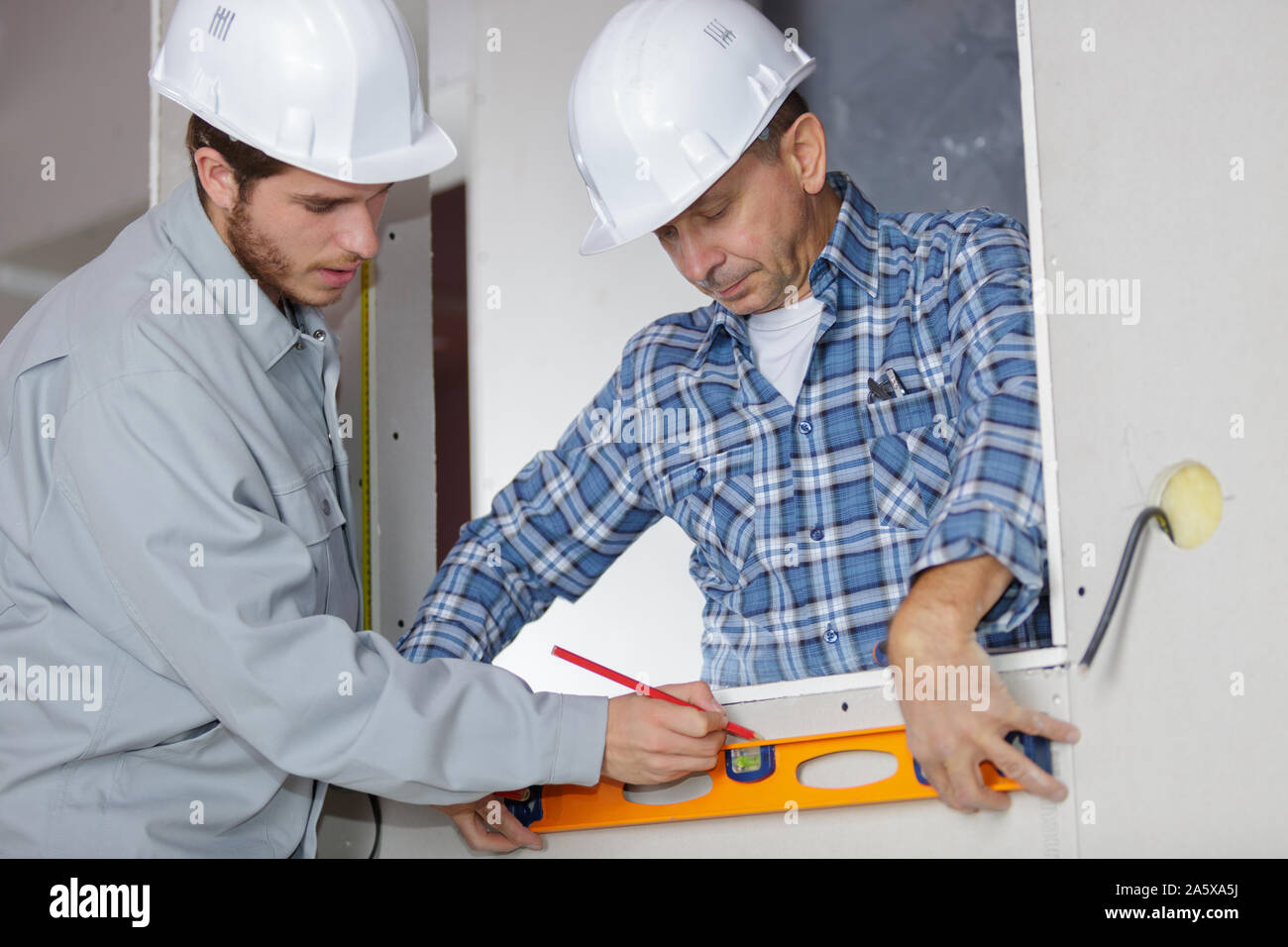 builders using spirit level horizontally Stock Photo - Alamy