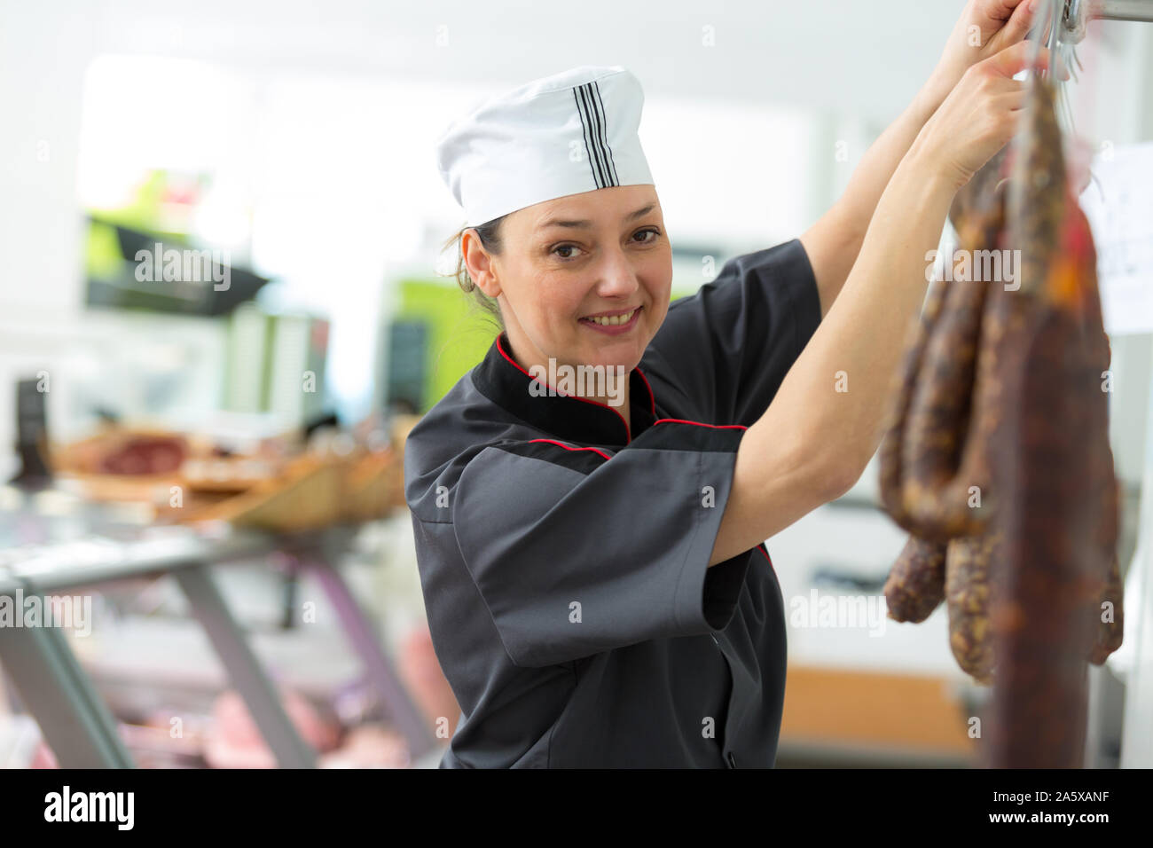 female butcher processing sausages at meat factory Stock Photo - Alamy