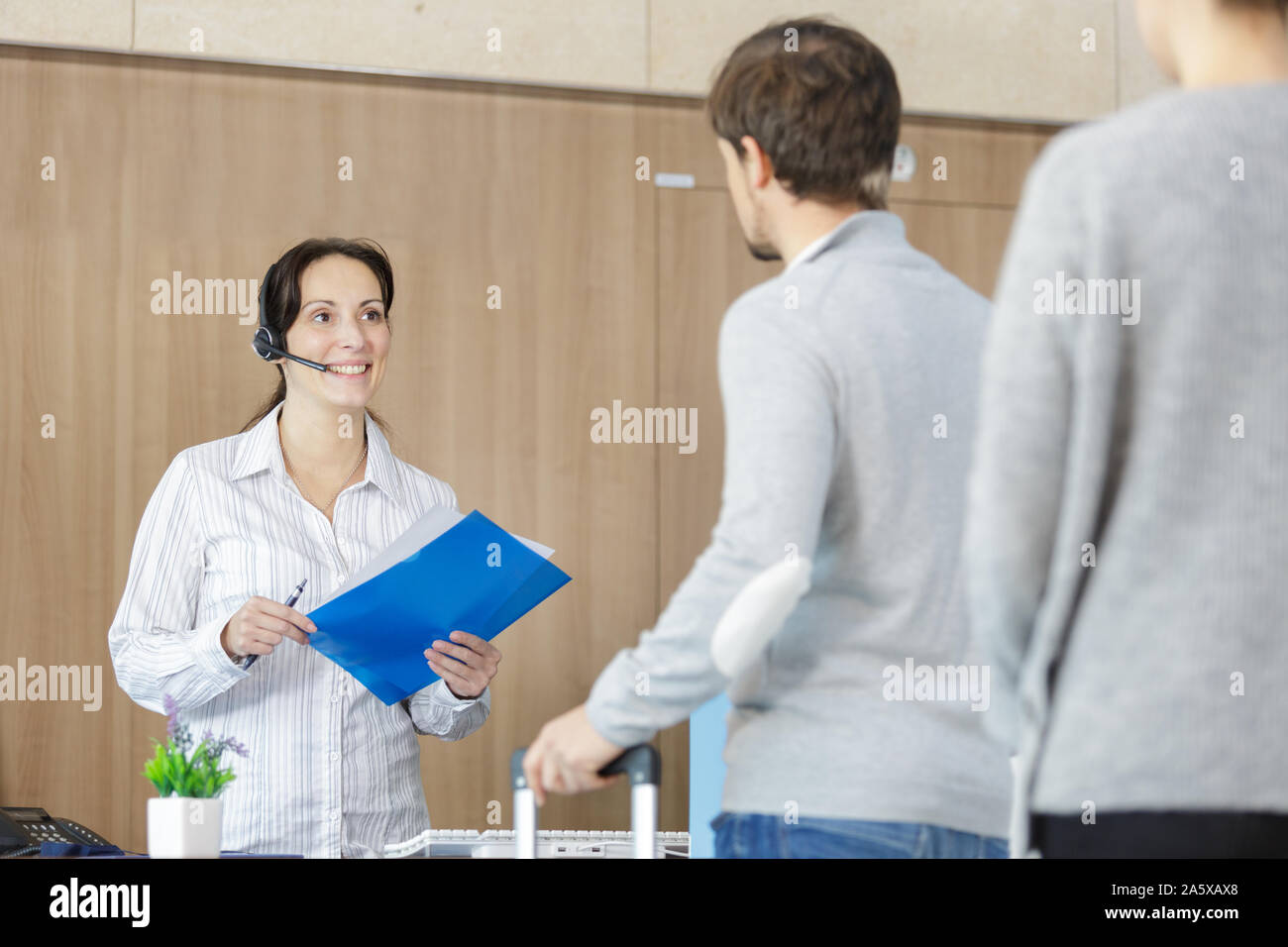 receptionist welcoming guest to hotel Stock Photo - Alamy