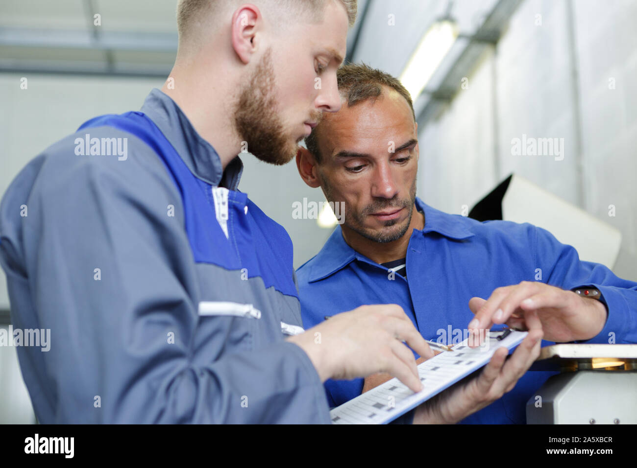 an automobile mechanic checking checklist Stock Photo - Alamy