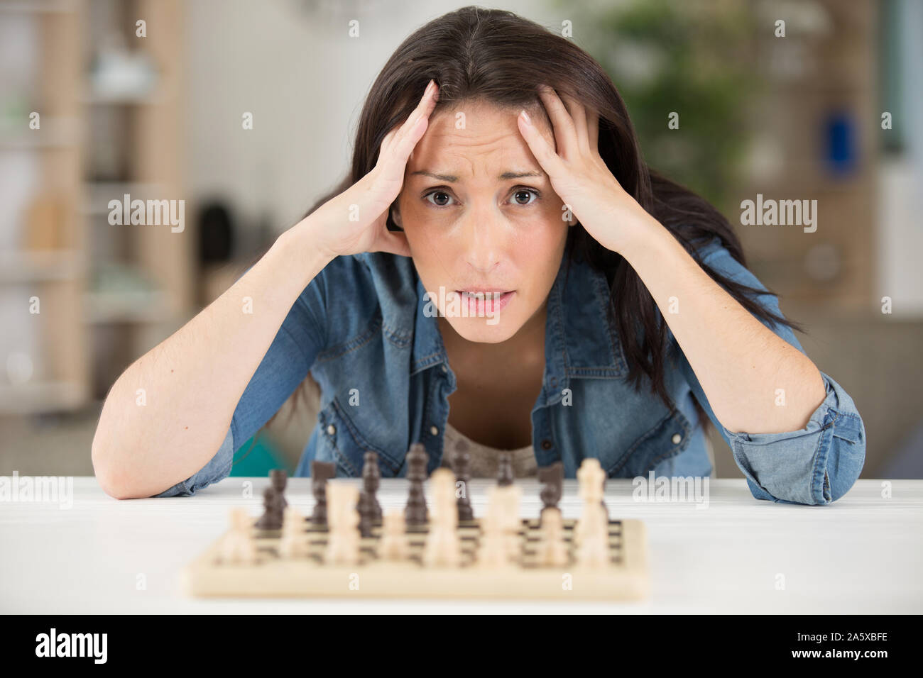 upset woman next to a chessboard Stock Photo - Alamy