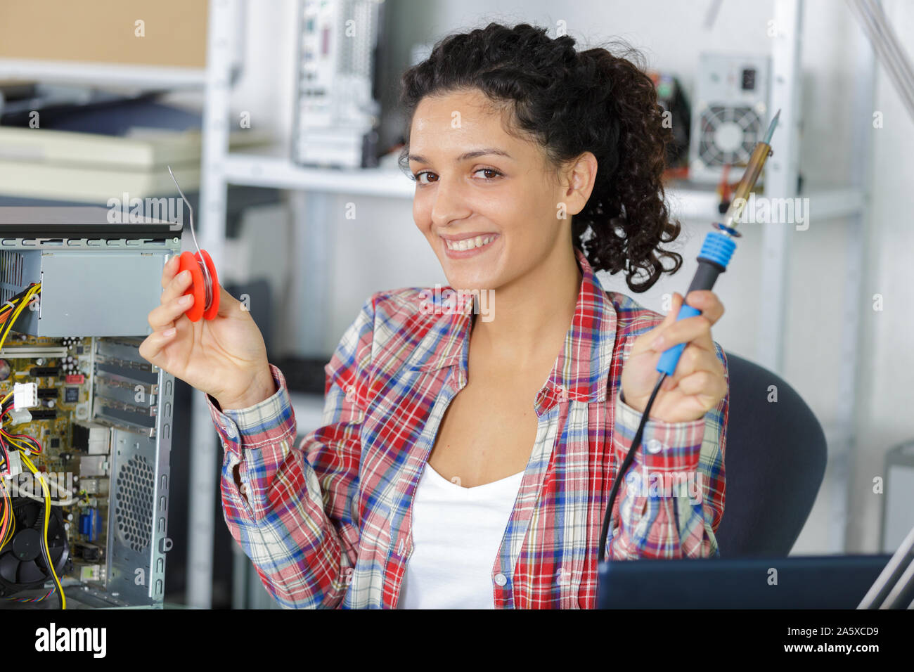 happy woman showing tools for soldering computer Stock Photo - Alamy