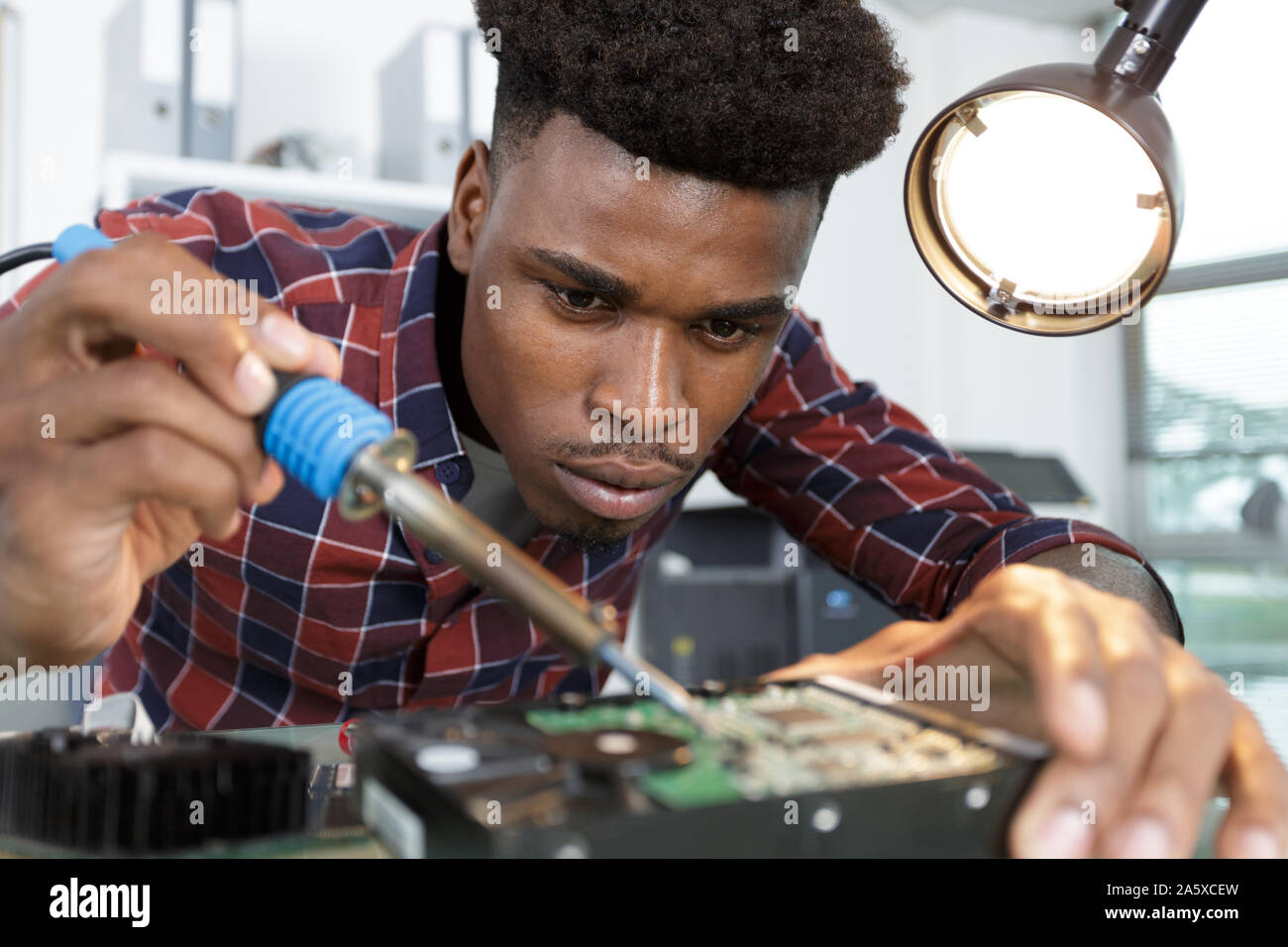 man solder a chip in a workshop Stock Photo - Alamy