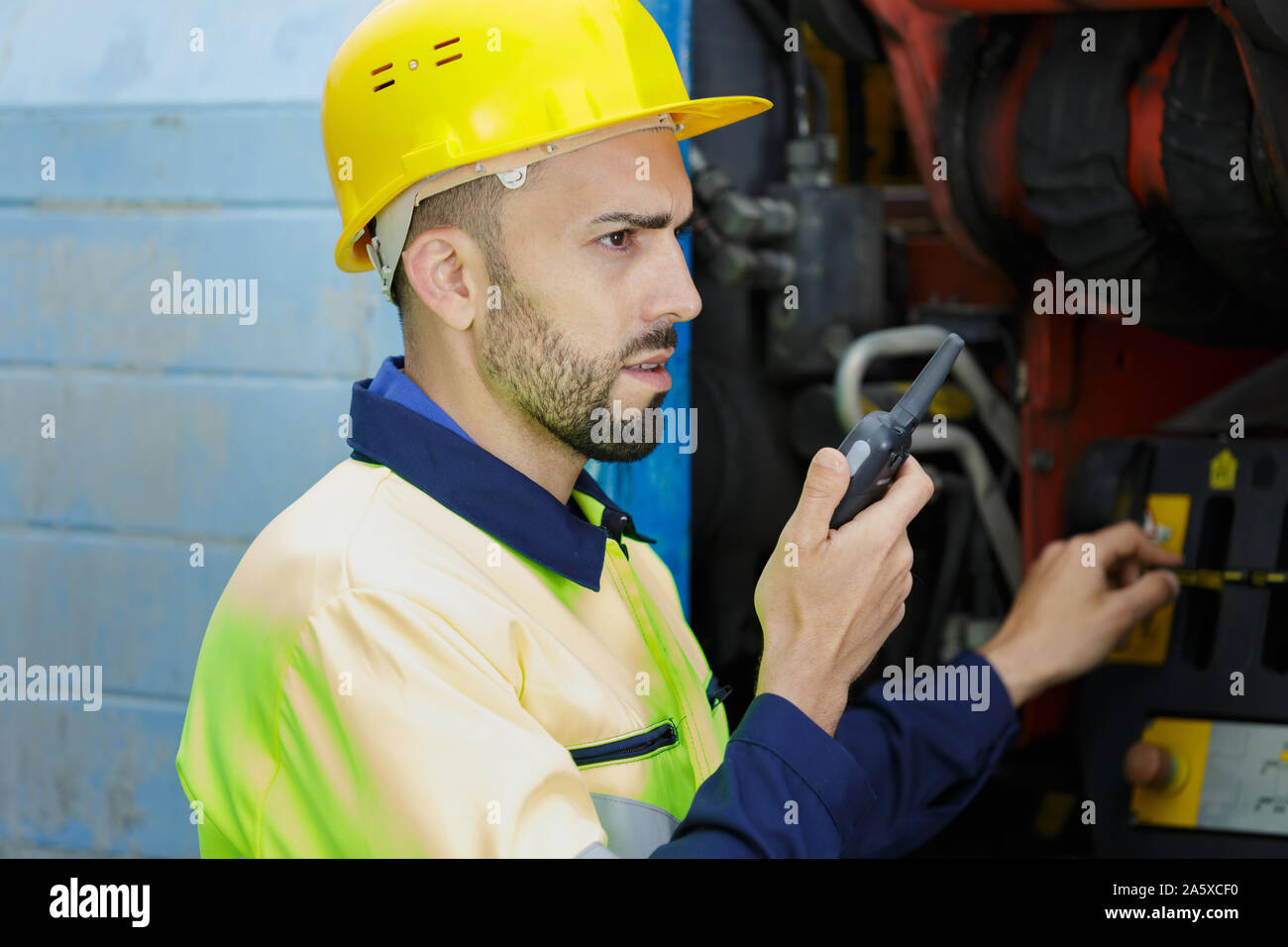 worker adjusting controls while speaking on walkie talkie Stock Photo ...