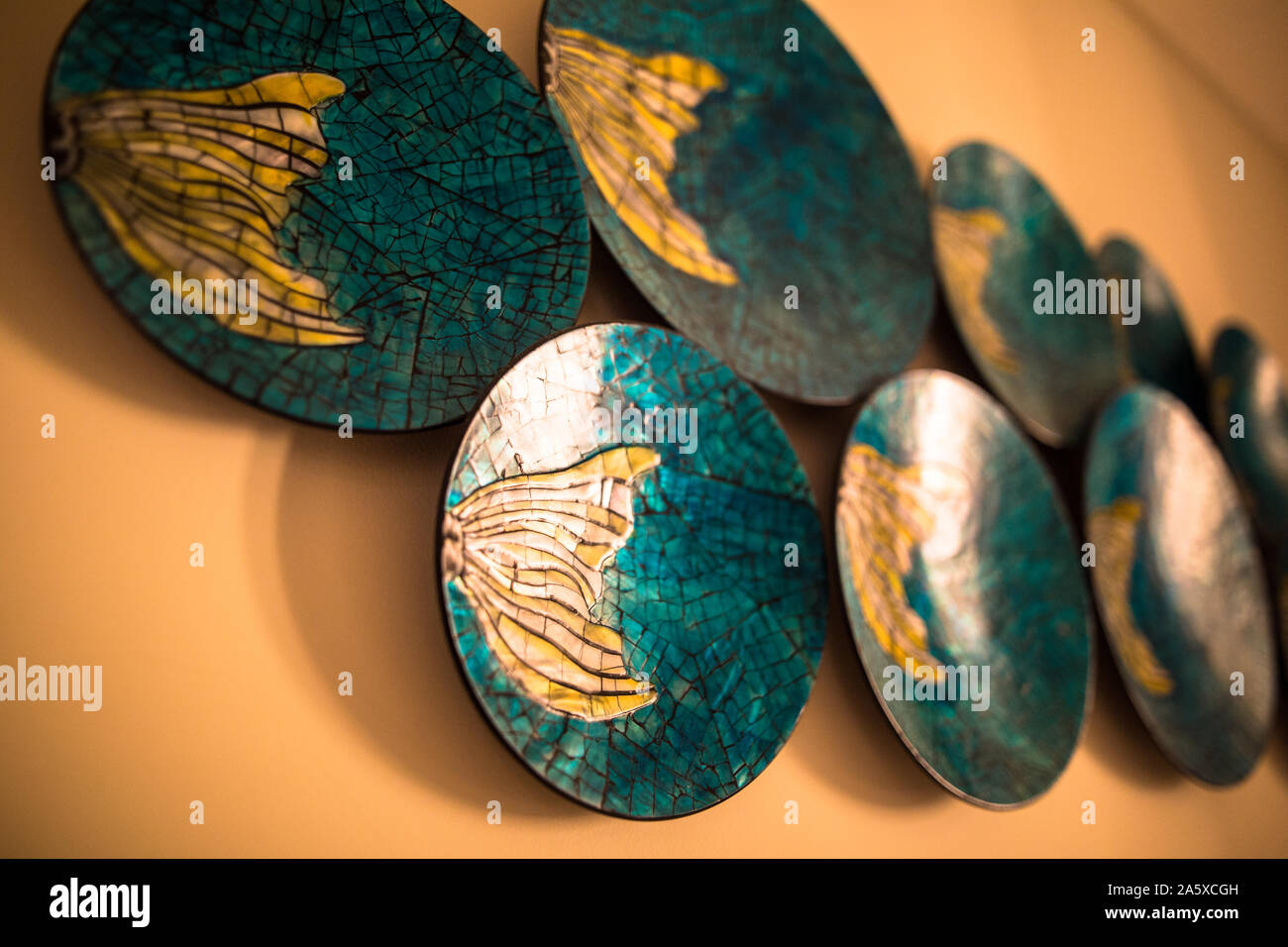 Ornamental plates with fish tail design hanging from wall as interior ...