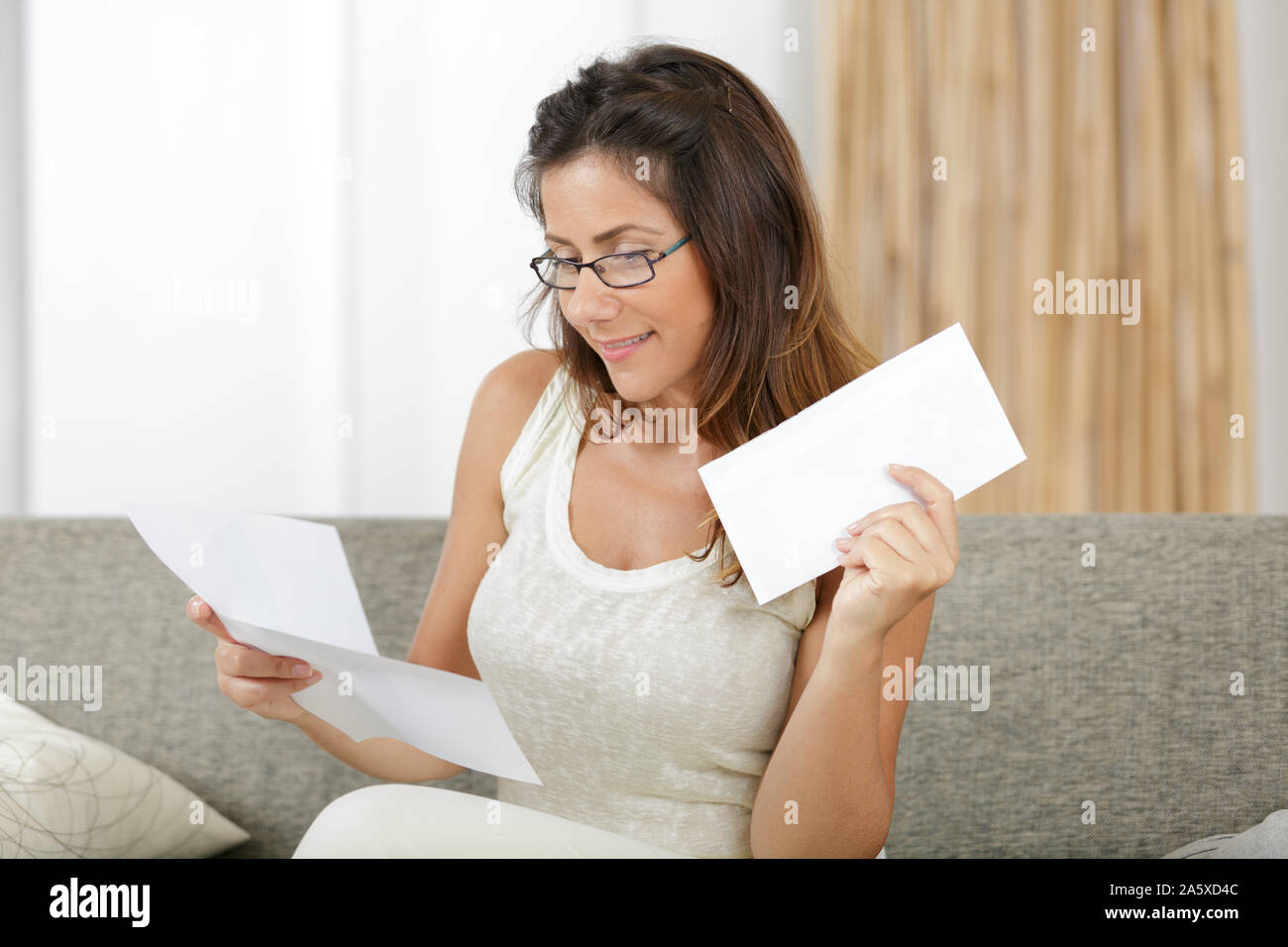 happy woman reading letter at home Stock Photo - Alamy