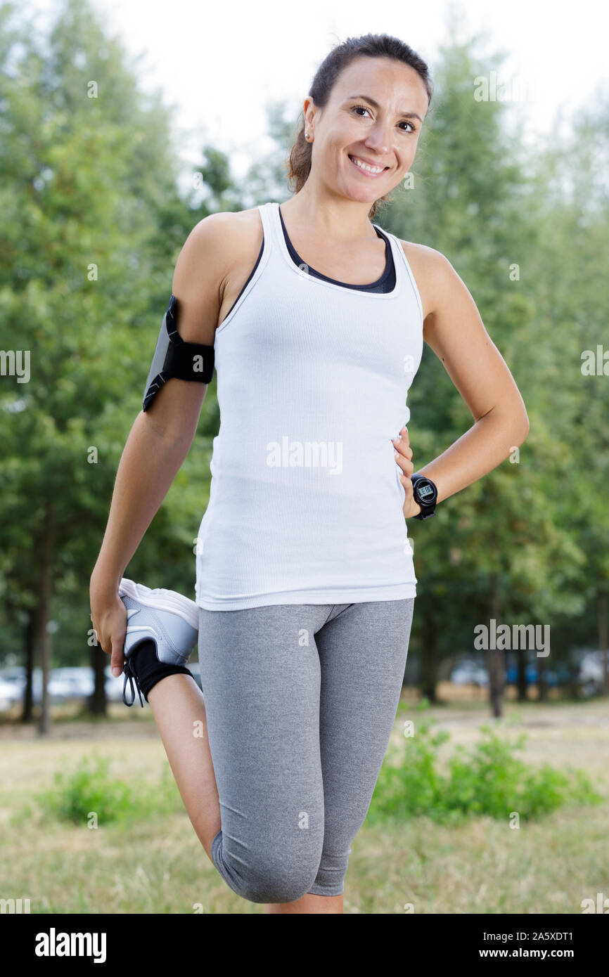 woman runner stretching leg in a city park rear view Stock Photo - Alamy