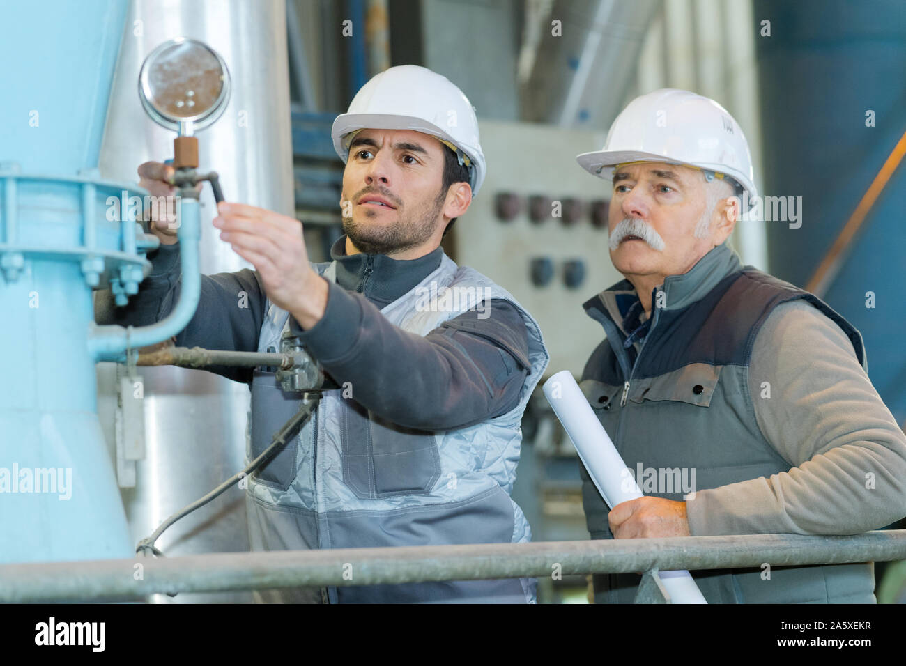 workers calibrating an industrial machine Stock Photo - Alamy
