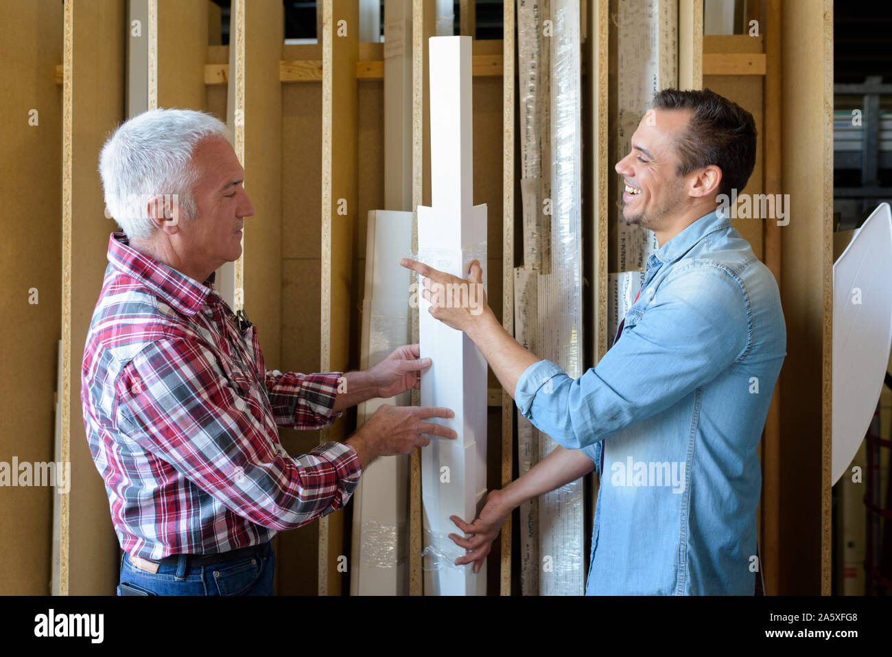 customer in lumber department of hardware store choosing wood strip ...