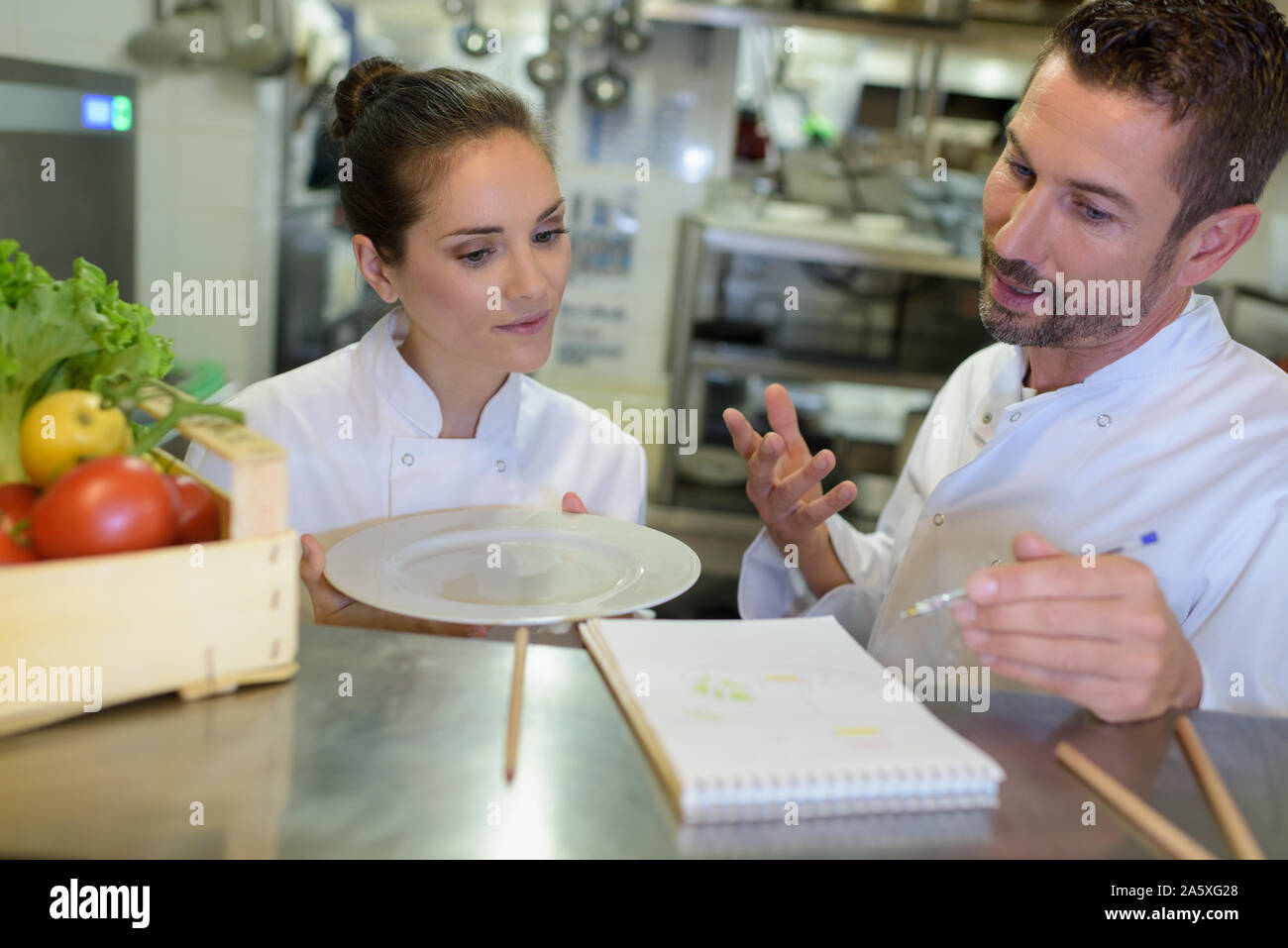 kitchen staff and chef having conversation Stock Photo - Alamy