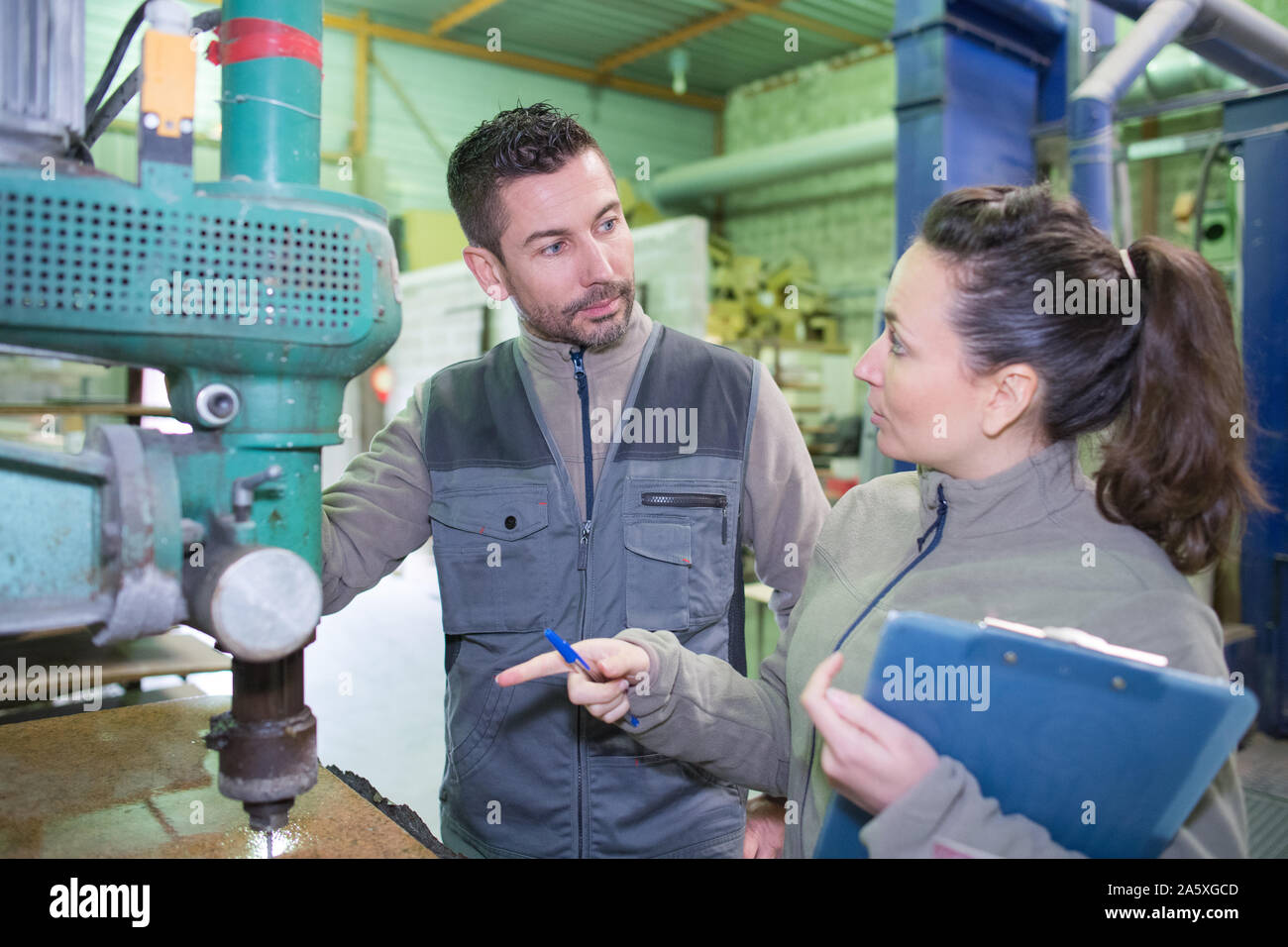 engineer training female apprentice on milling machine Stock Photo - Alamy