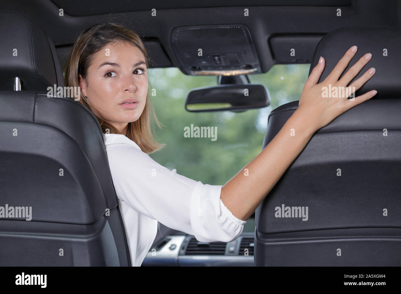 young woman driver reversing car Stock Photo - Alamy