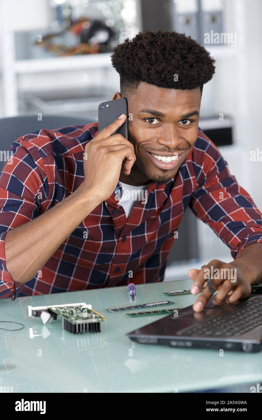 young handsome on the phone repairman repairing computer Stock Photo ...