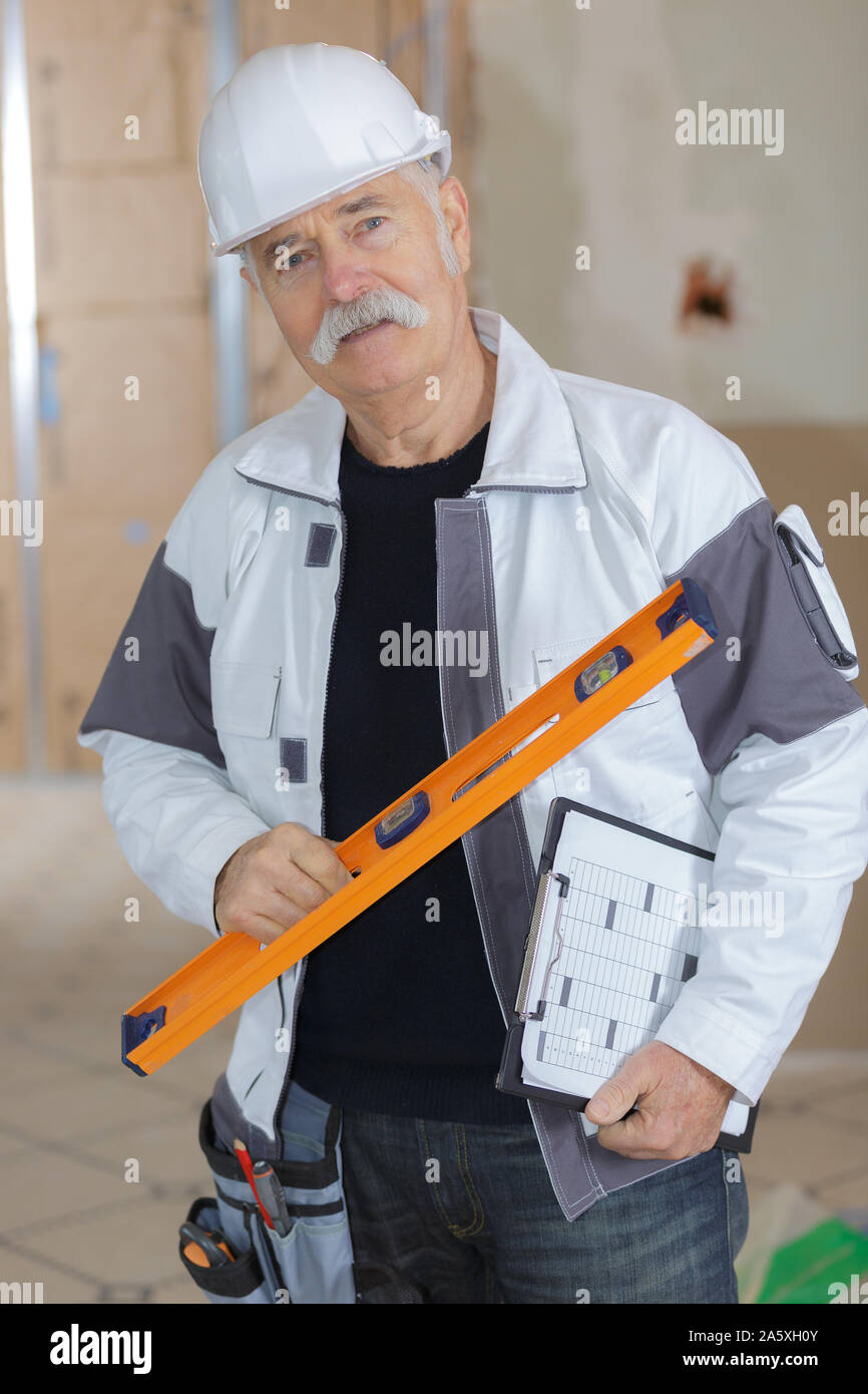 builder holding building level at construction site Stock Photo - Alamy
